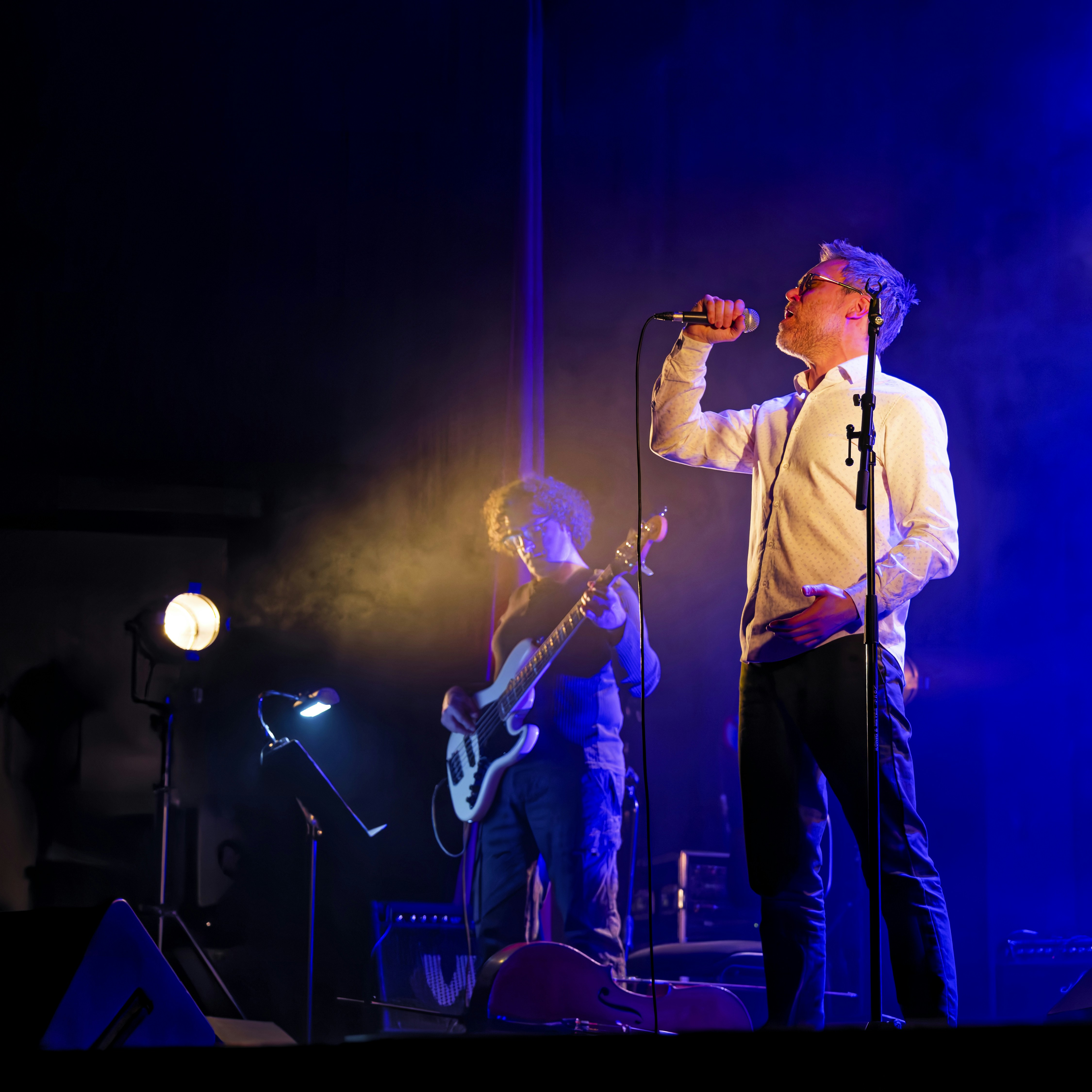 Spotlight Pulse: A Vocal Moment Under Blue and Gold