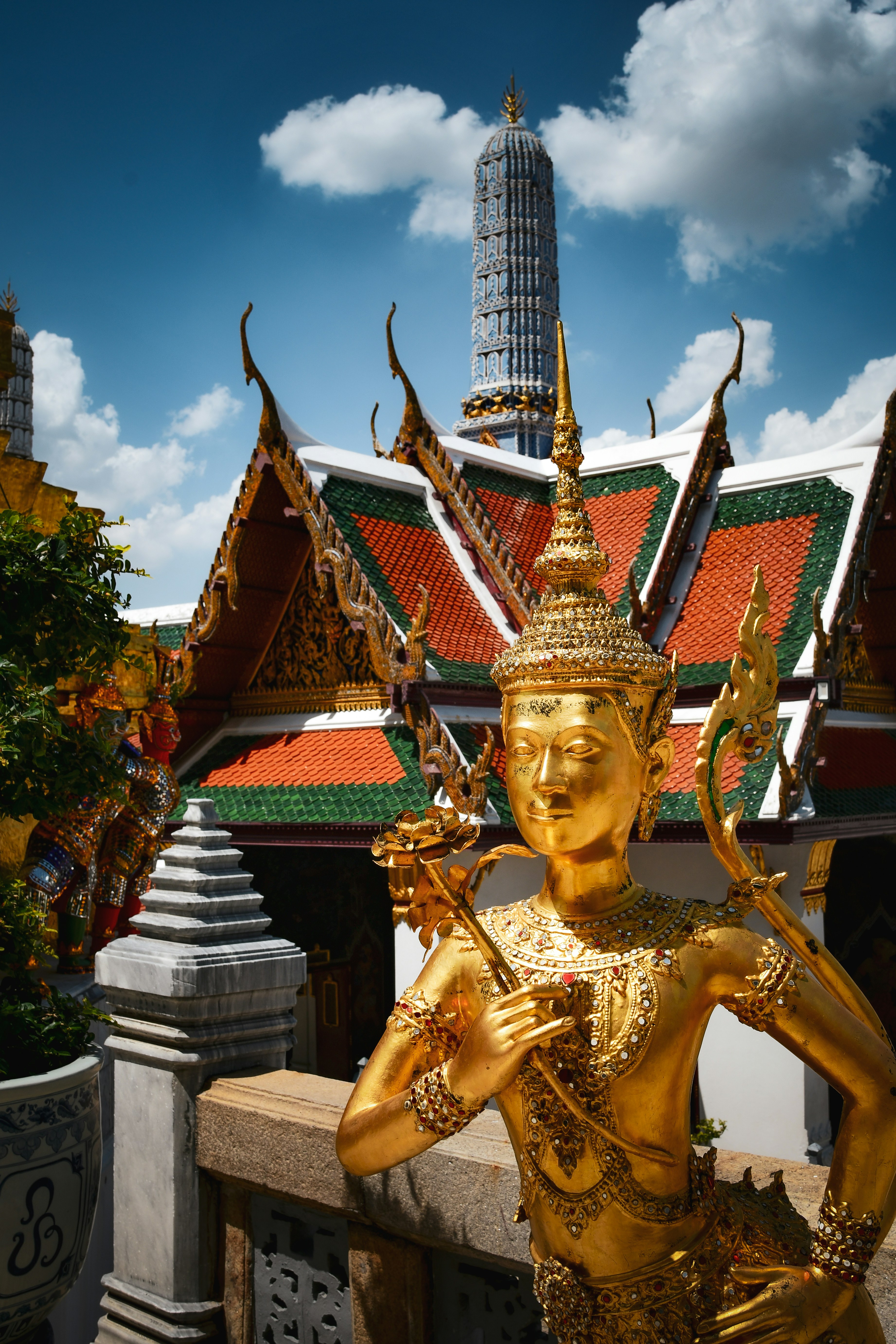 Golden Guardian: A Shrine Statue Framed by Ornate Temple Roofs