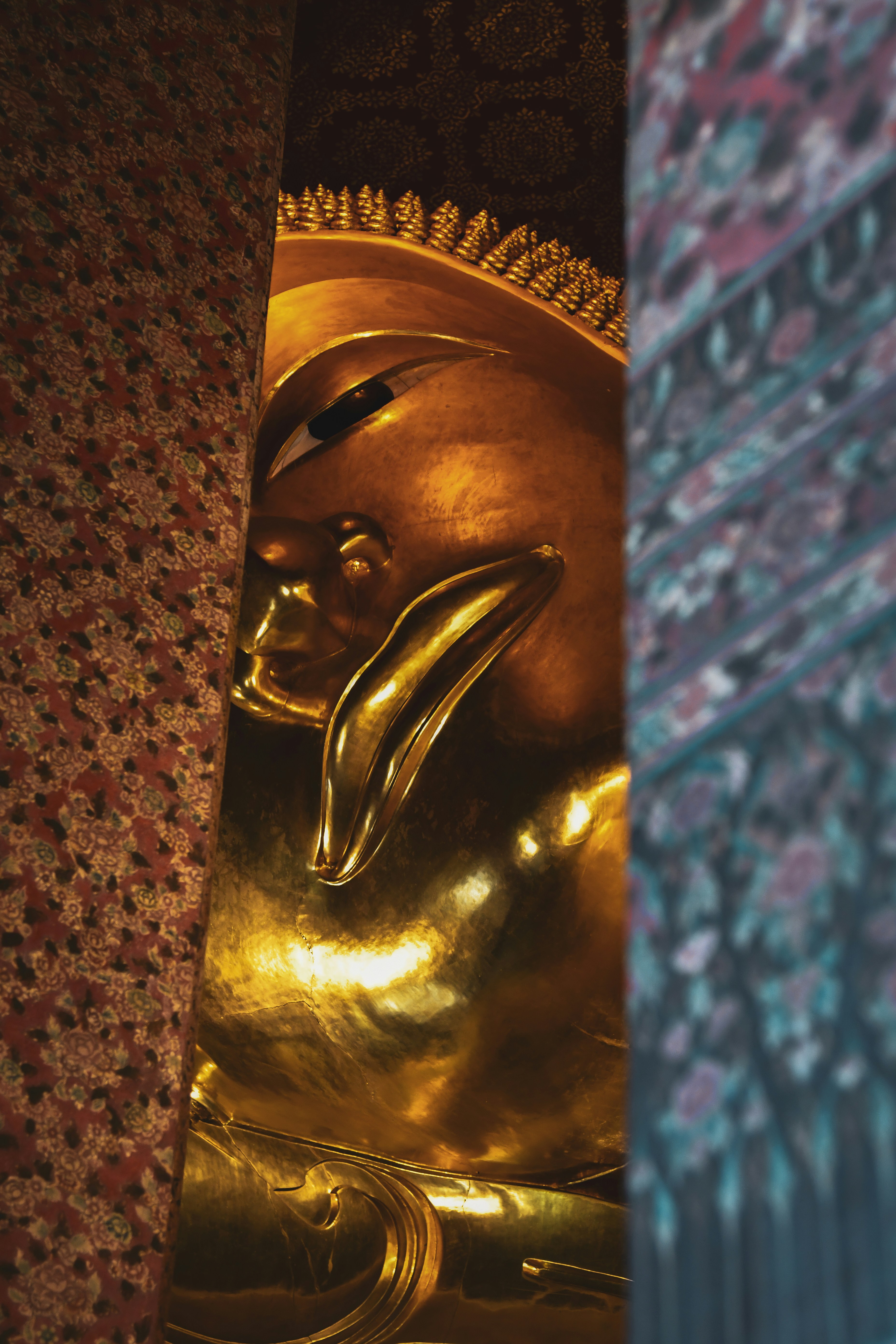 Golden Buddha between ornate fabric corridors