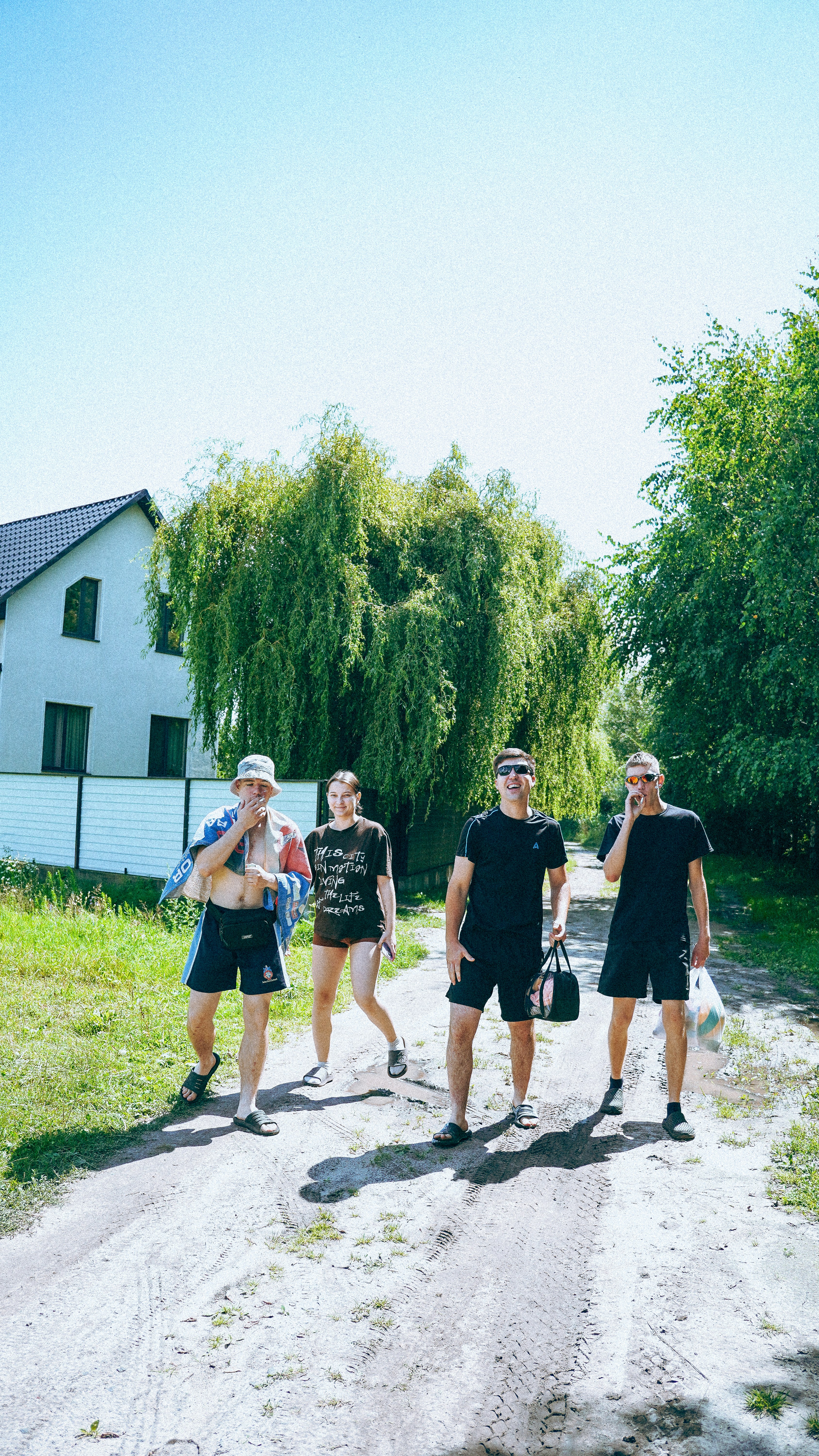 Four Friends Stride Down a Sunlit Rural Path