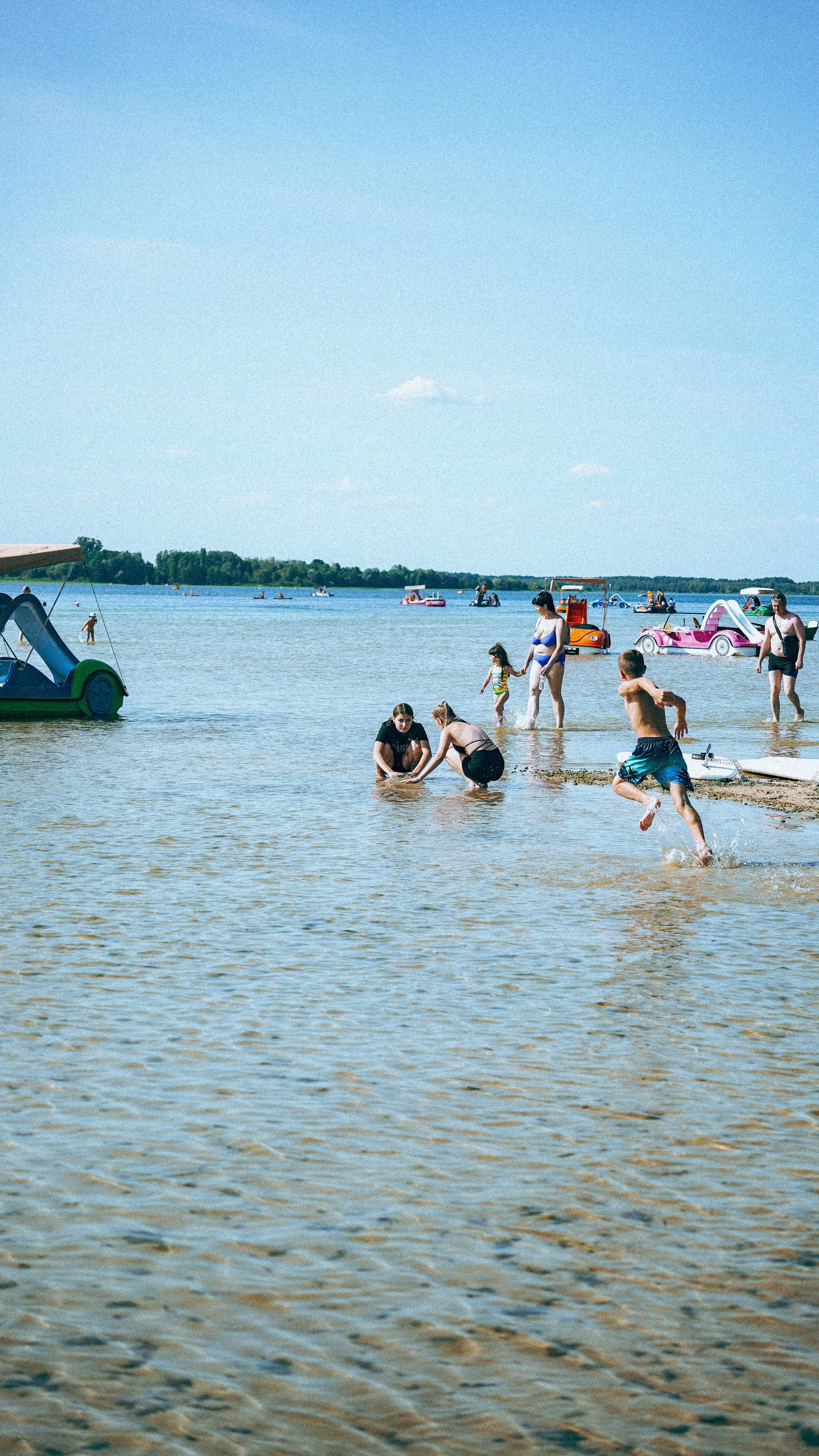 Sunlit Shores: Children and Boats at the Warm Lake Edge
