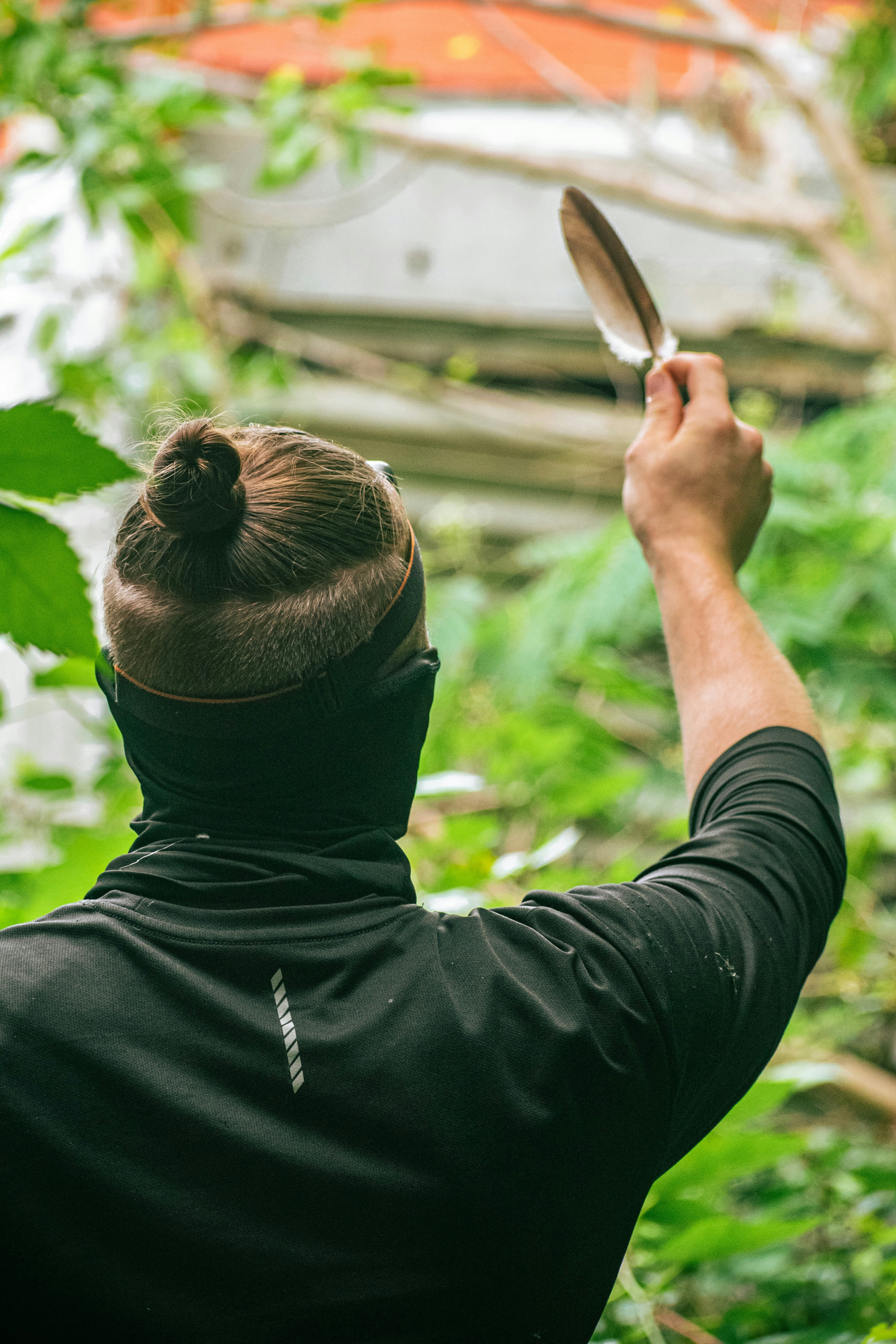 Raising a Knife of Focus: Hands and Blade in a Lush Backyard