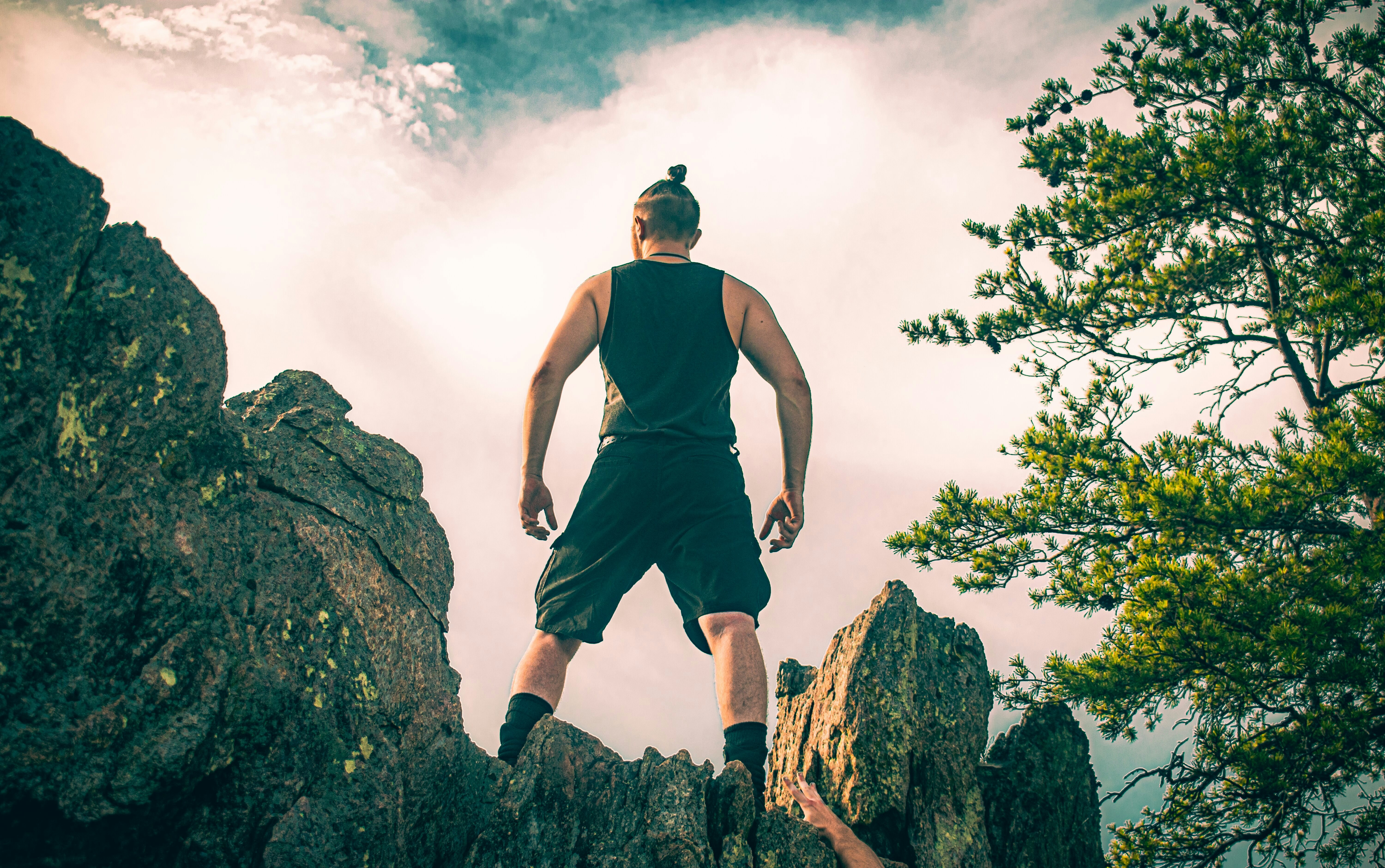 Cliffbound Ascent: Solitary Explorer on a Craggy Peak