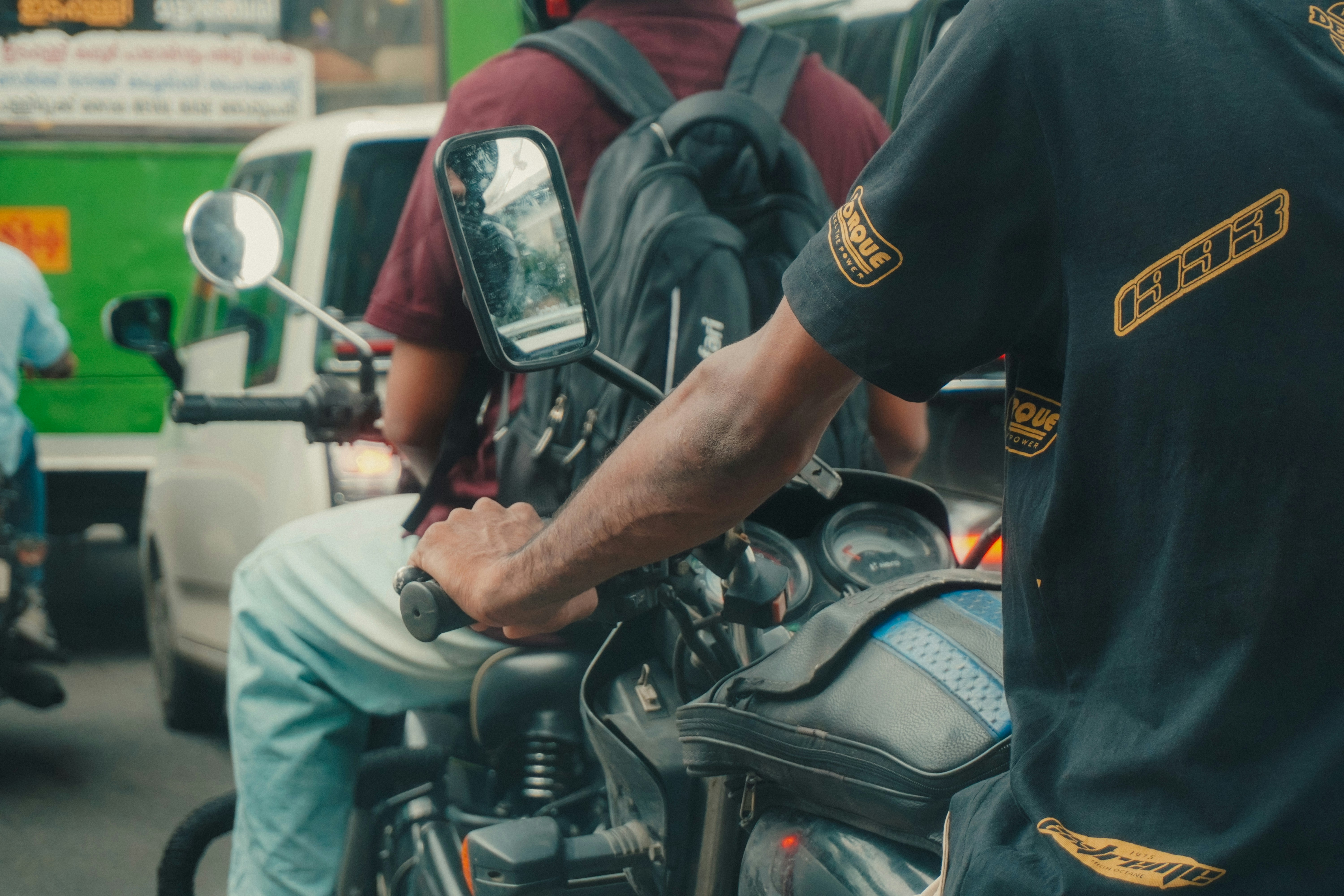 Riders and a chrome mirror: a busy street scene from a bike taxi vantage