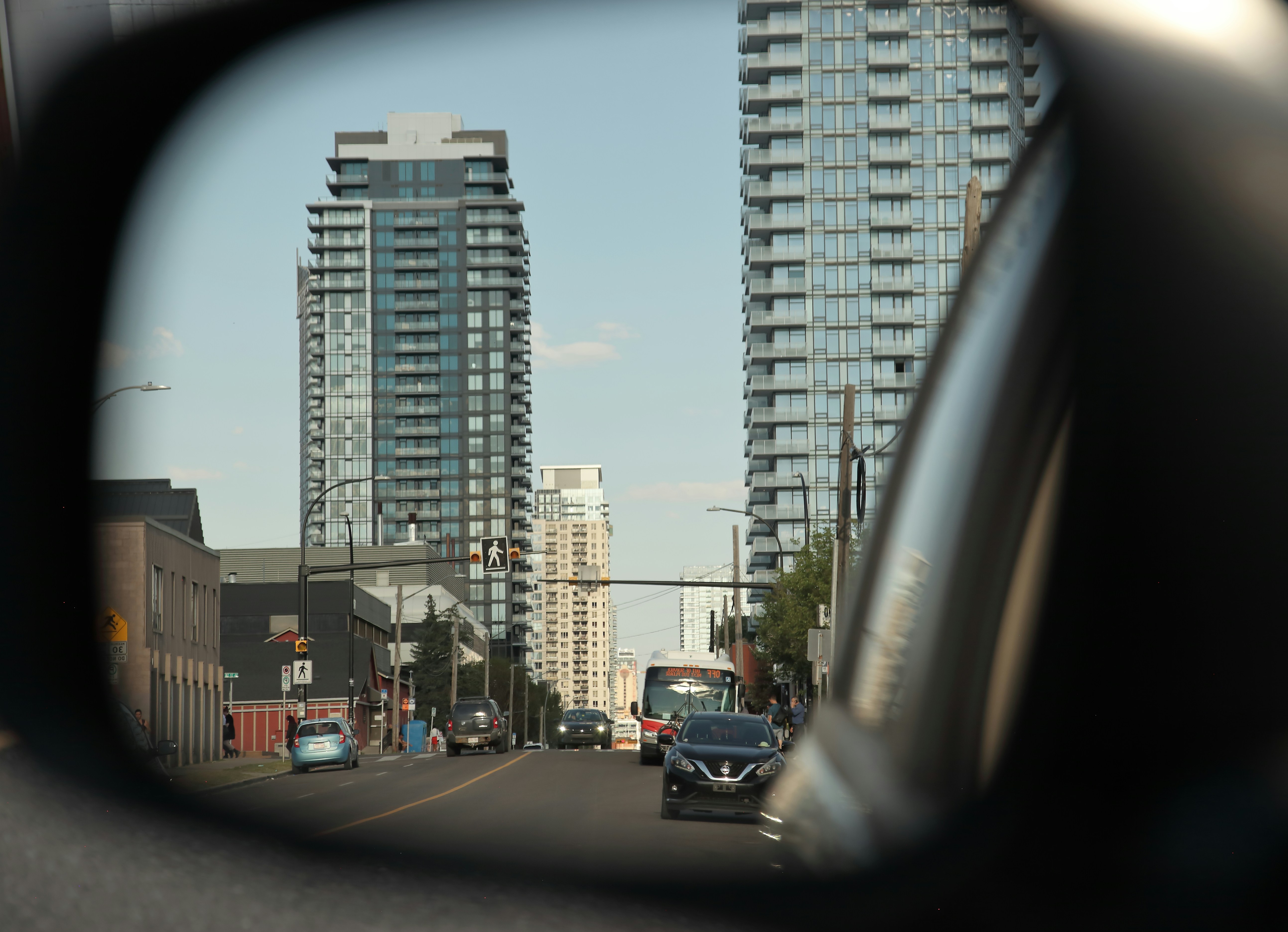 Rising Towers Framed by a Street Scene in the Rear-View Window