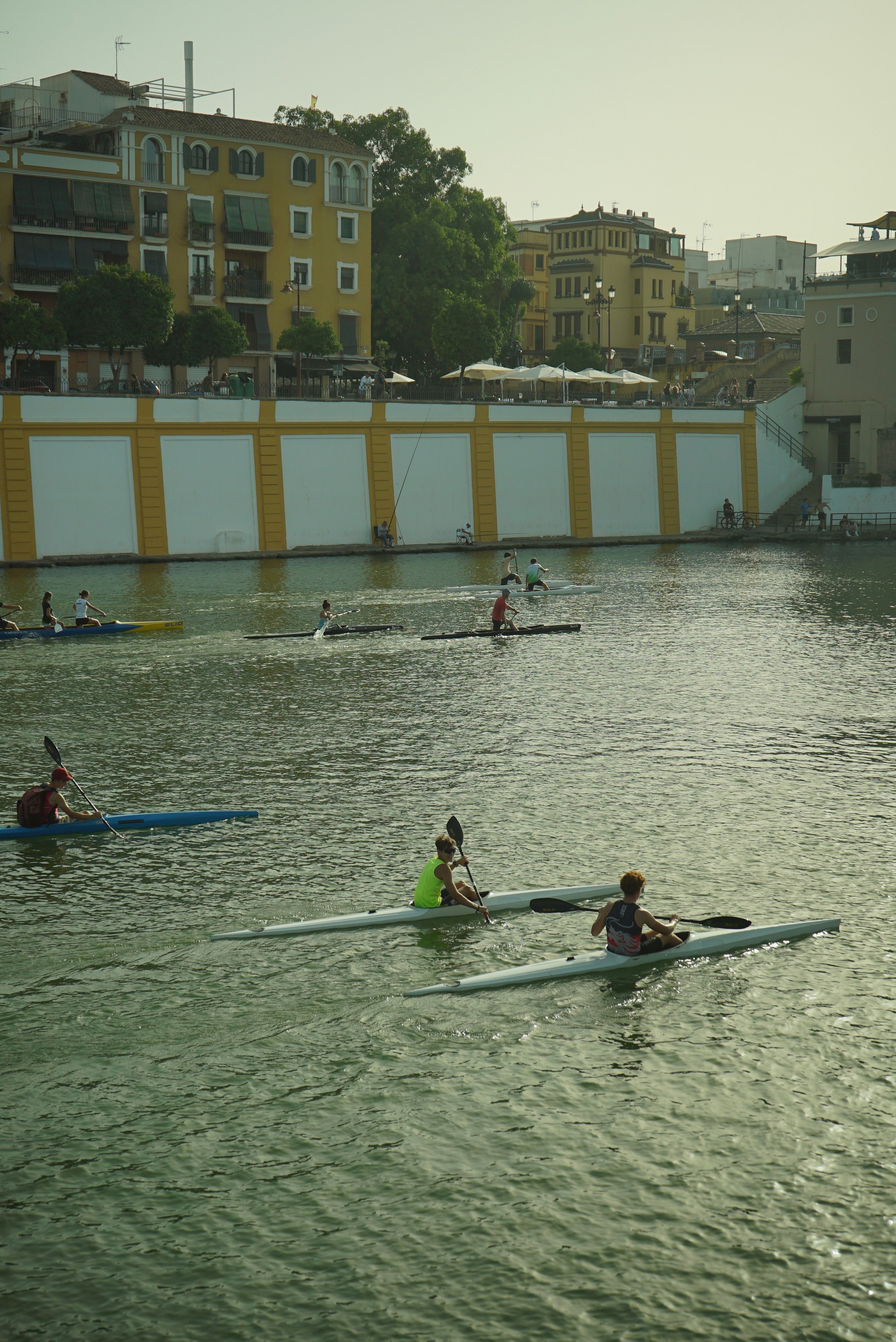 River Regatta: Kayaks Slice Through Sunlit Green Waters