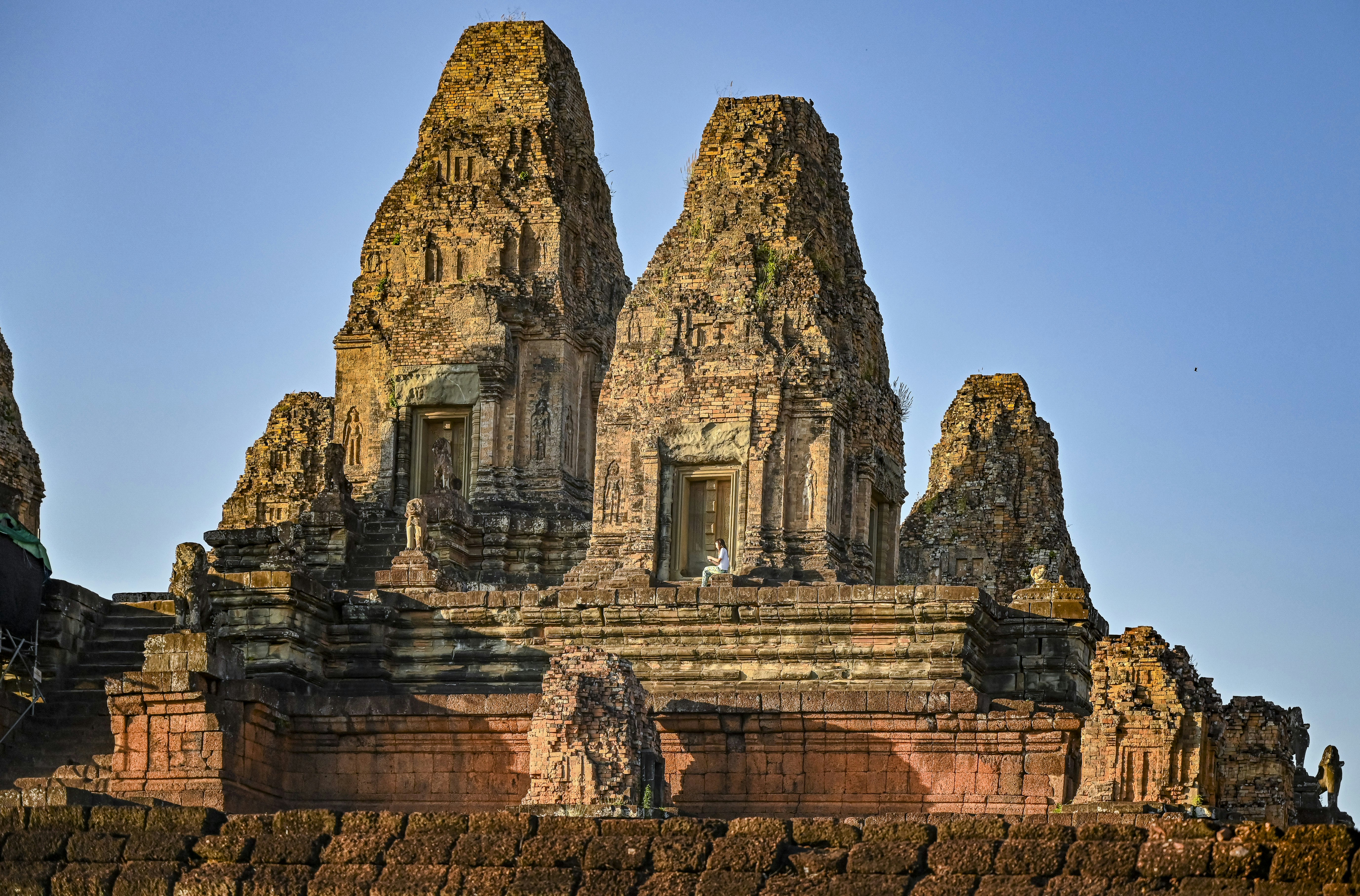 Twin Towers of Angkor: Weathered Faces Rising Over Crumbling Steps