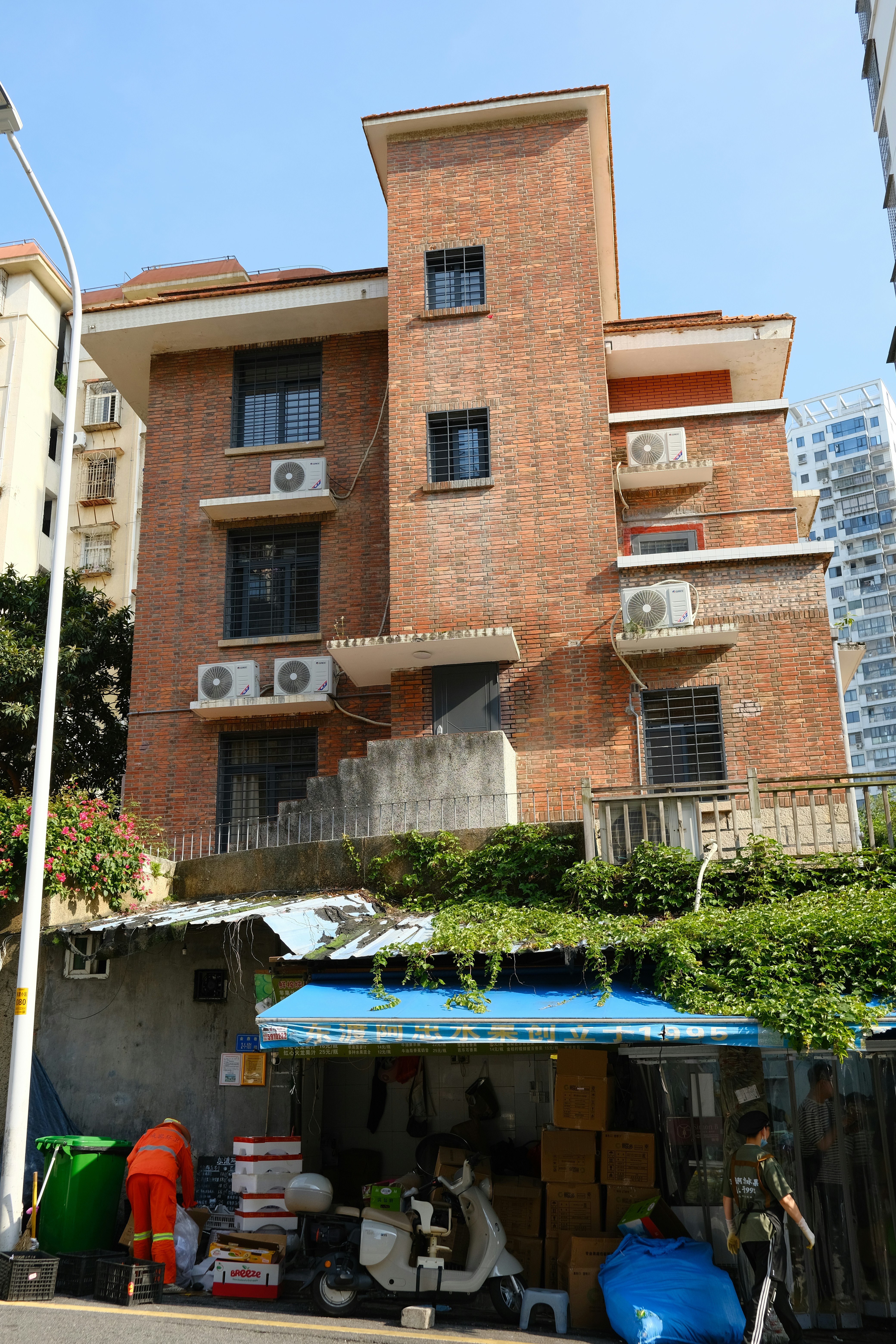 Brick Facade, Air Conditioners, and Street-Level Activity under a Bright Urban Sky