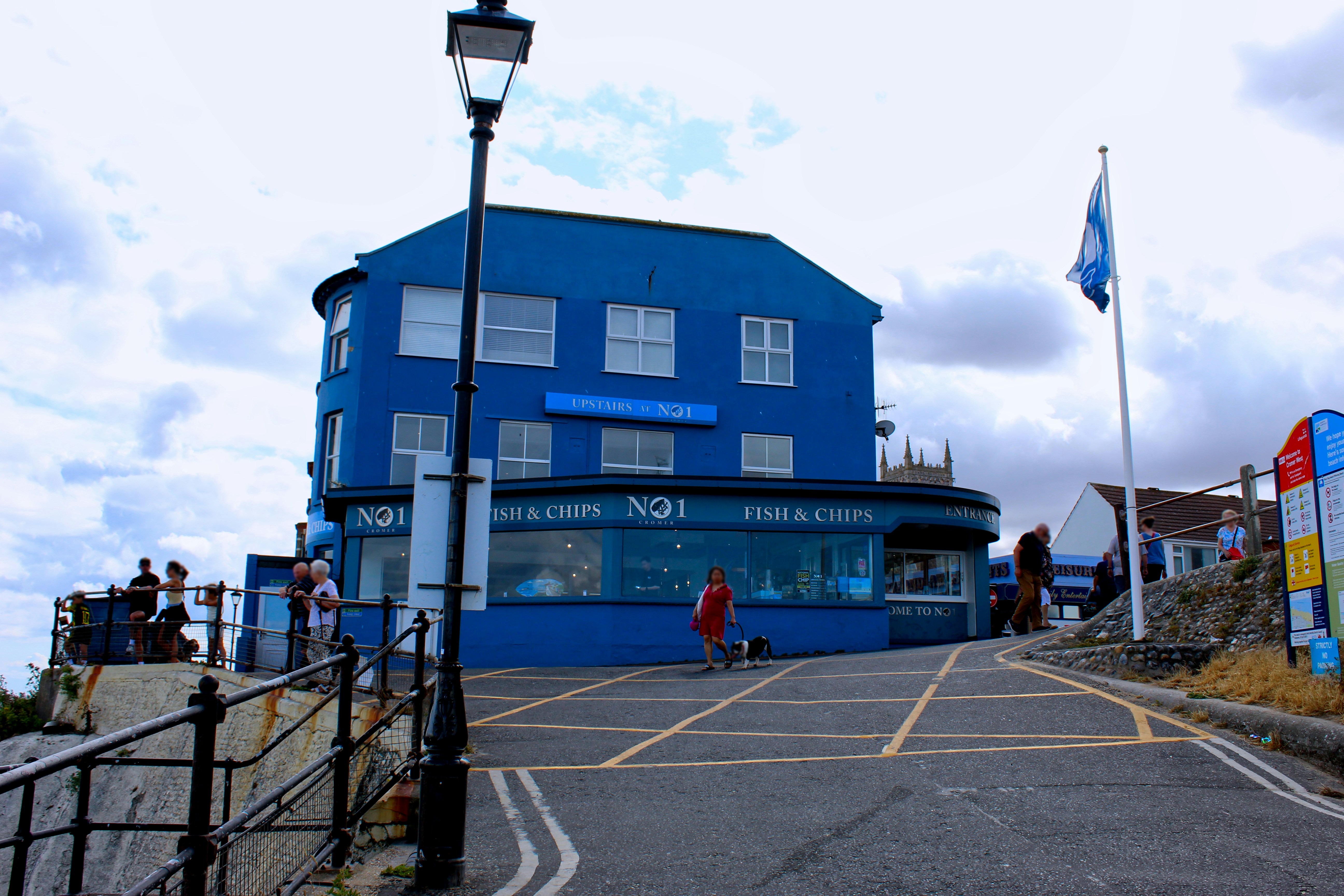 Blue Seafront Café Rising Above the Sloped Walkway