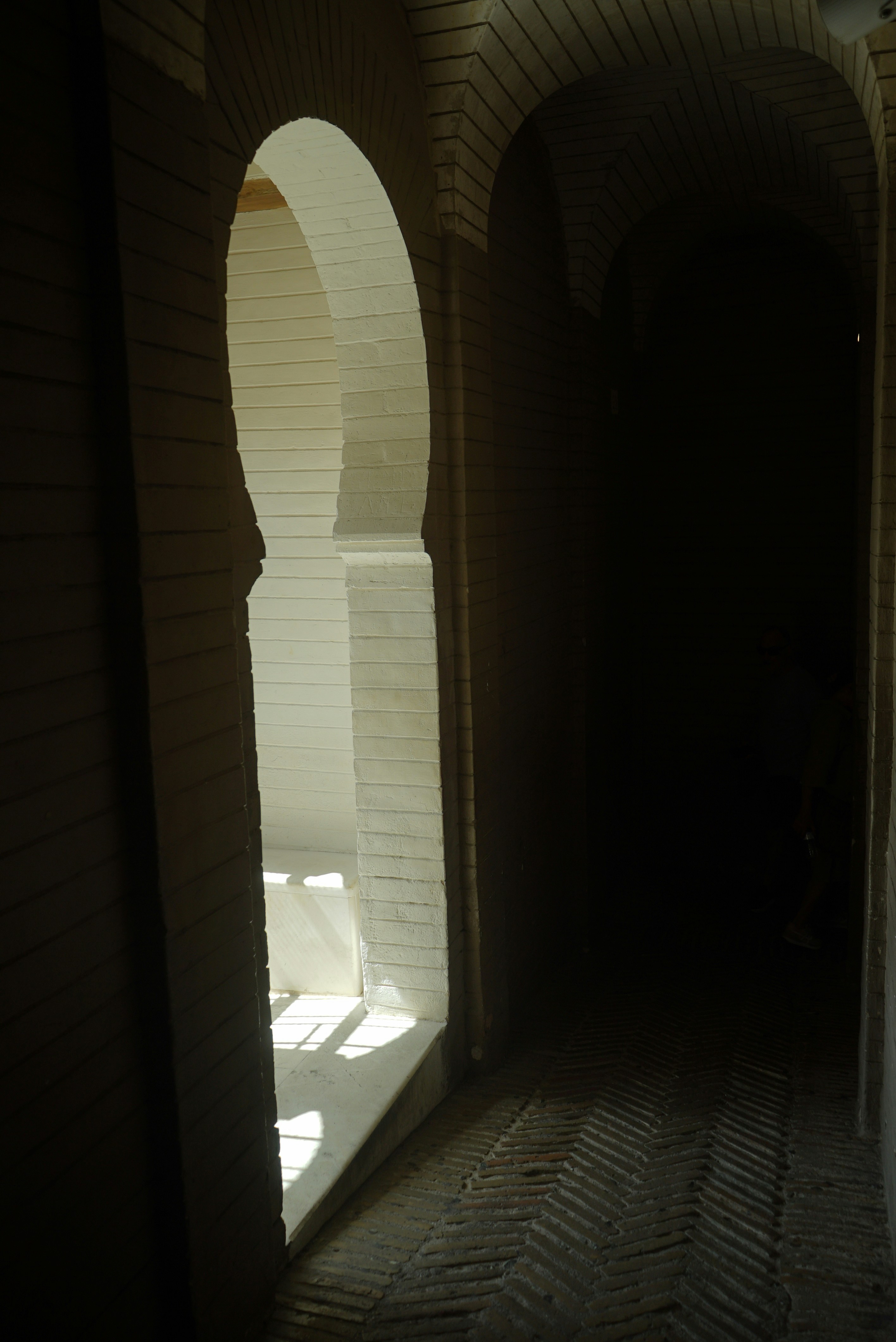 Light at the Arch: A Sunlit Portal in a Bricked Corridor
