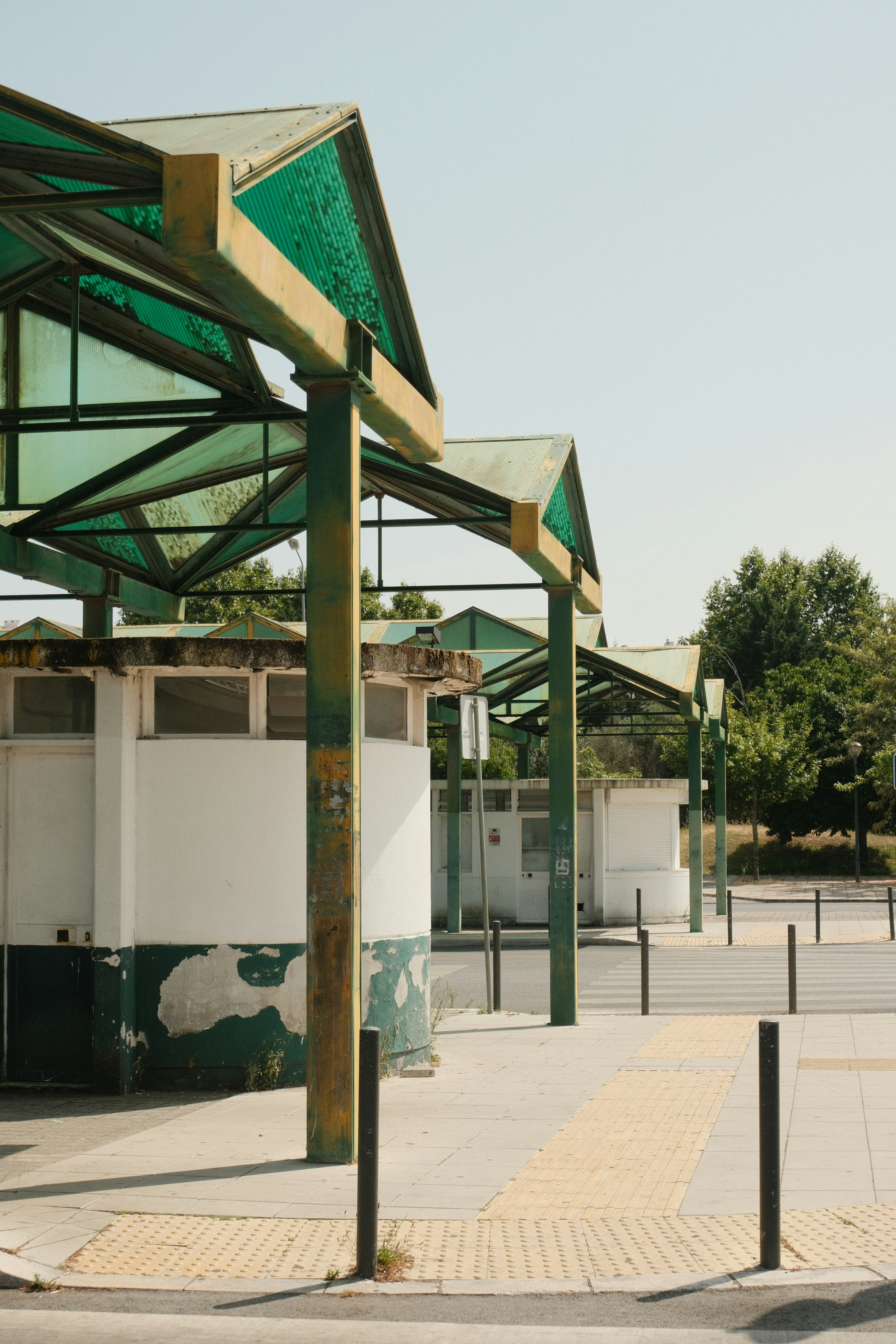 Abandoned Transit Shelter Receding into Sunlit Street