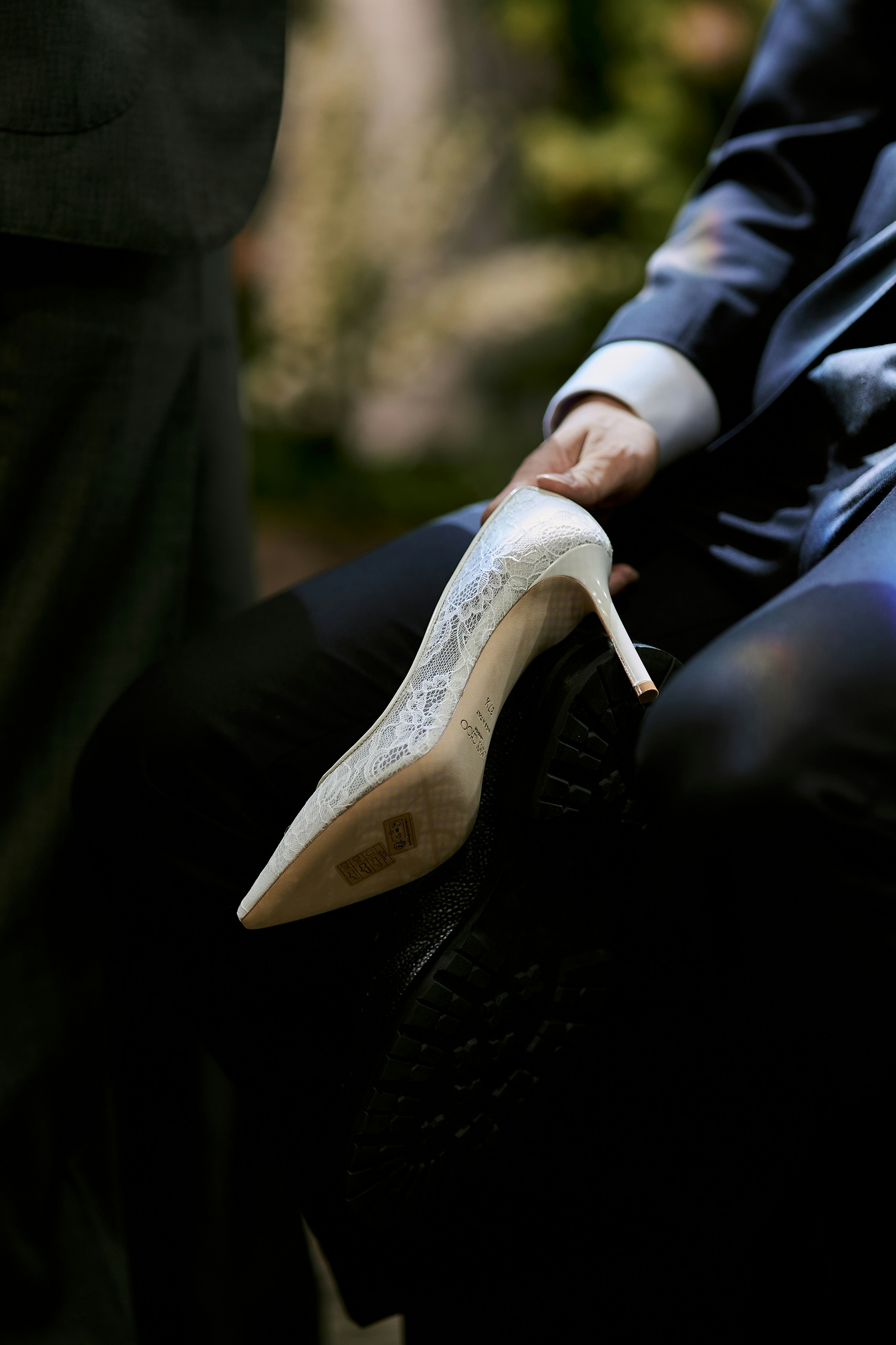 A Quiet Moment: Groom Helped with a White Lace Heel