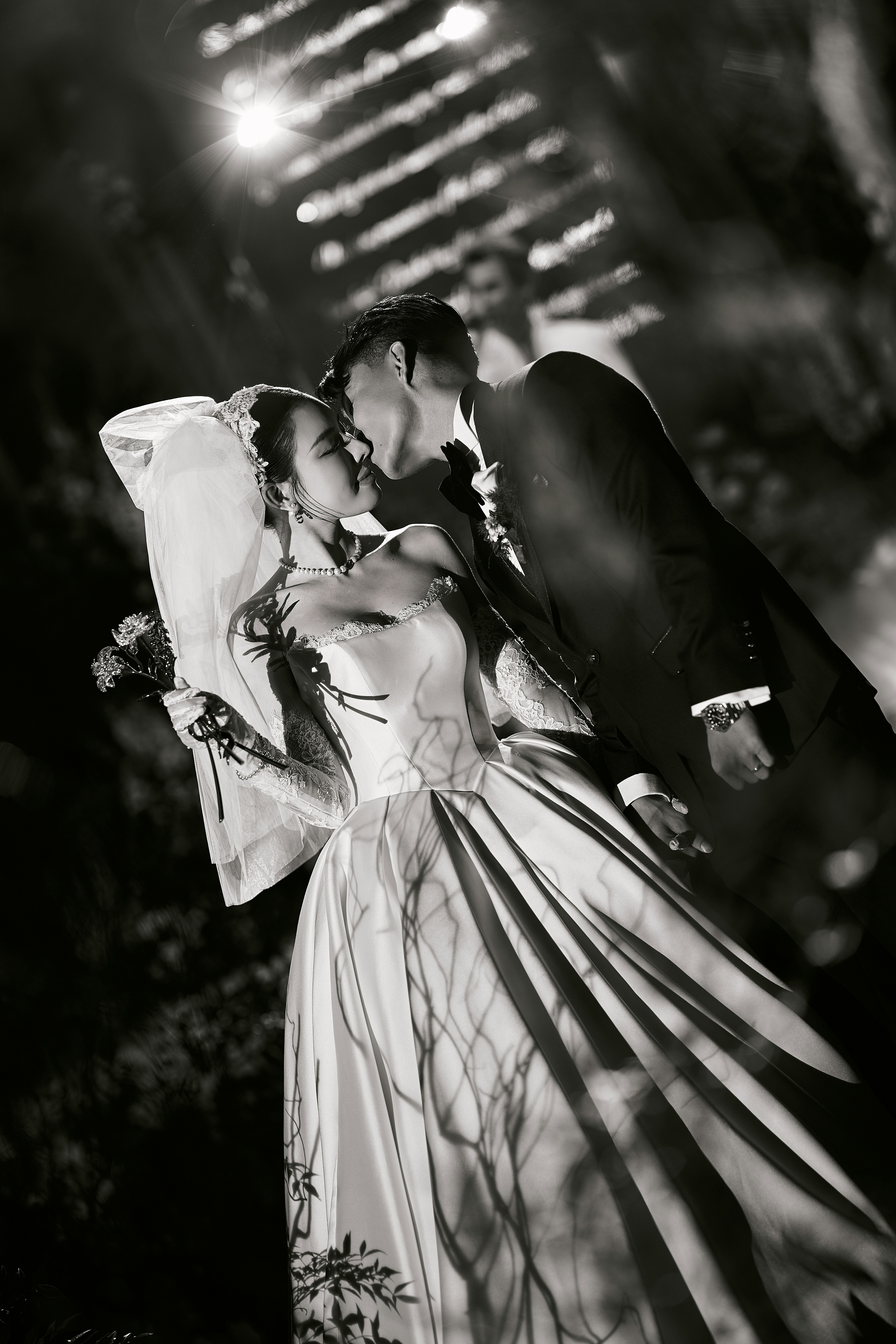 Kiss Under Moonlit Veil: A Wedding Moment in Soft Focus