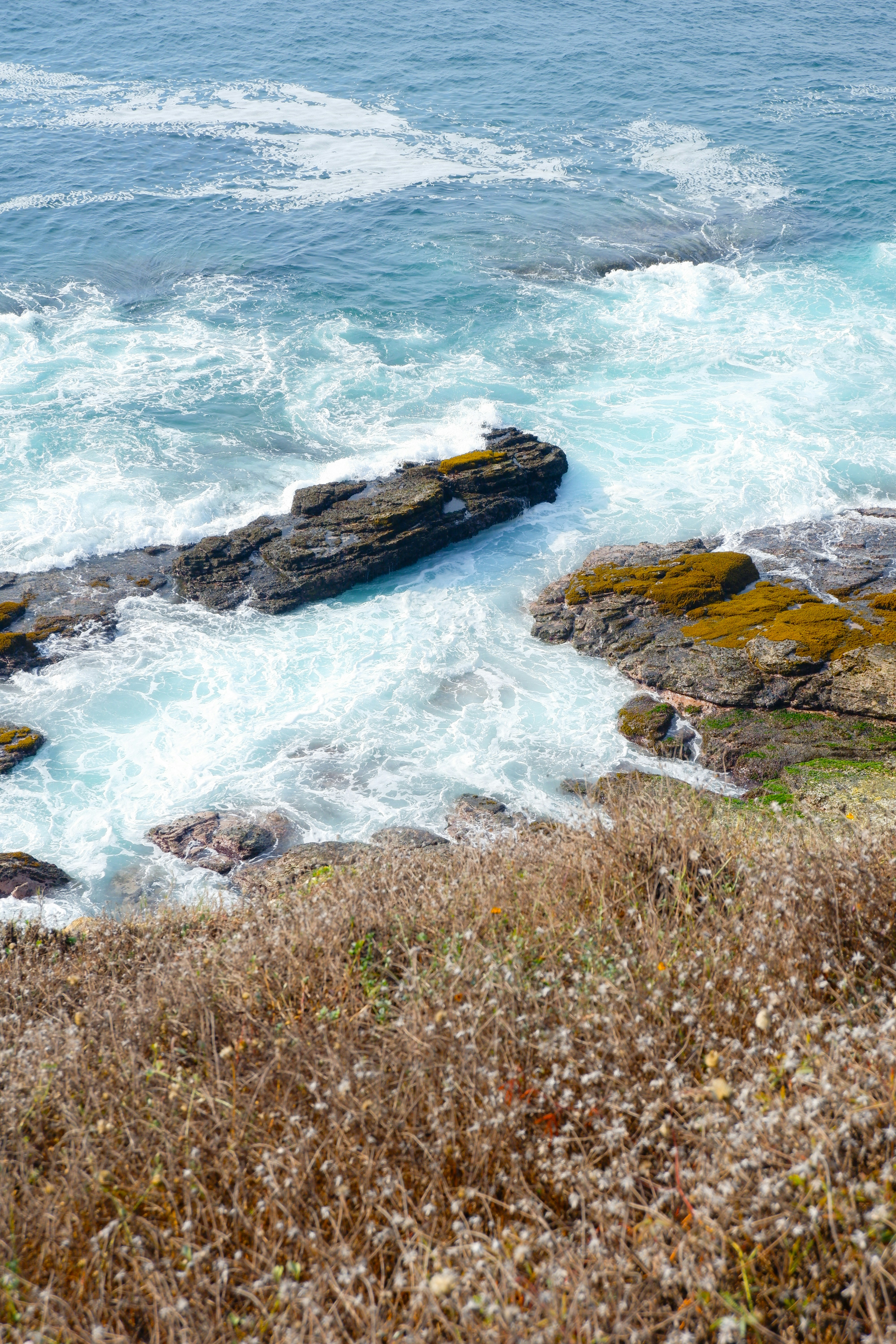 Coastal Cliffside Overlook: Tide-Washed Rocks and Seafoam