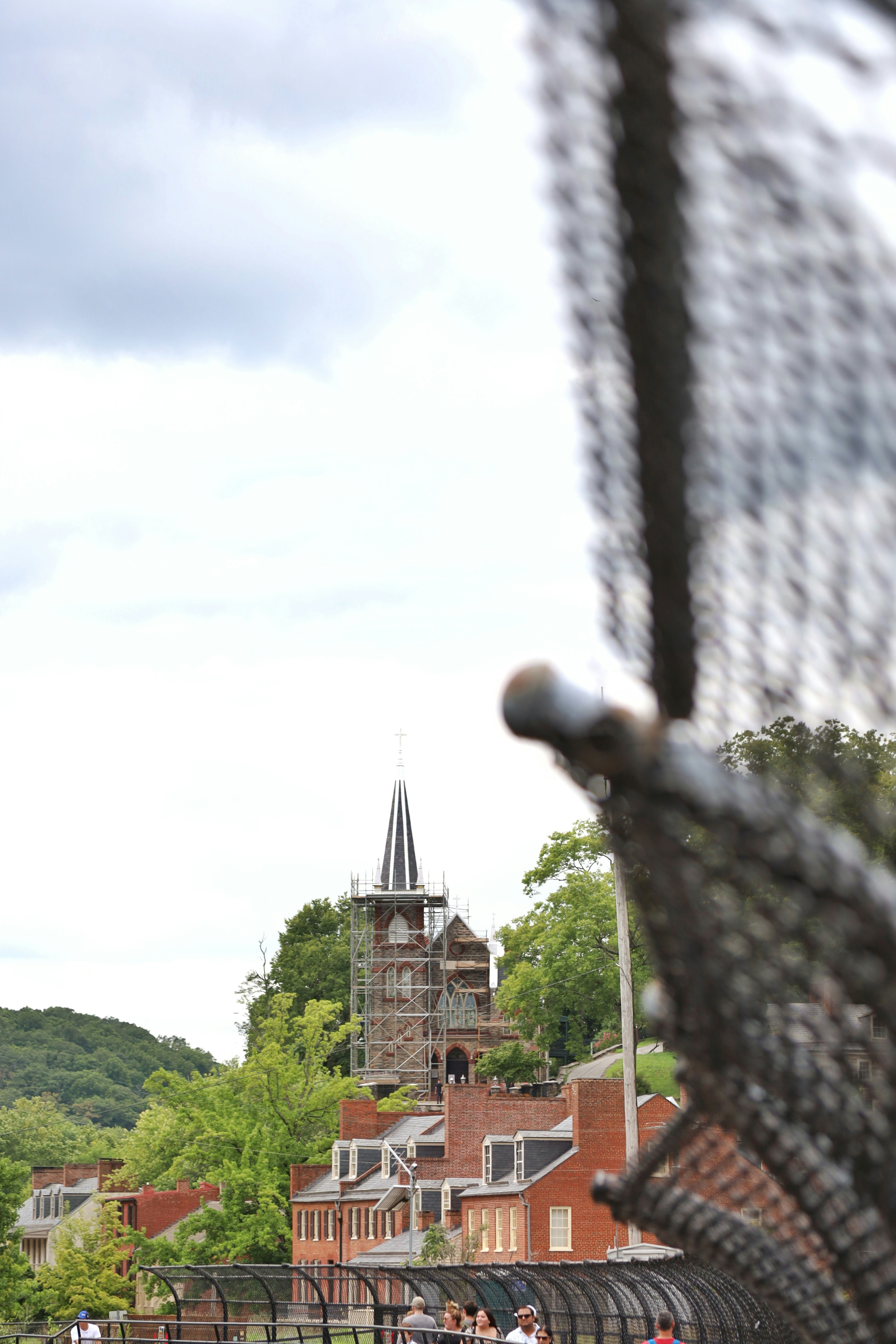 A Historic Clock Tower Emerging Beyond a Chain-Link Barrier