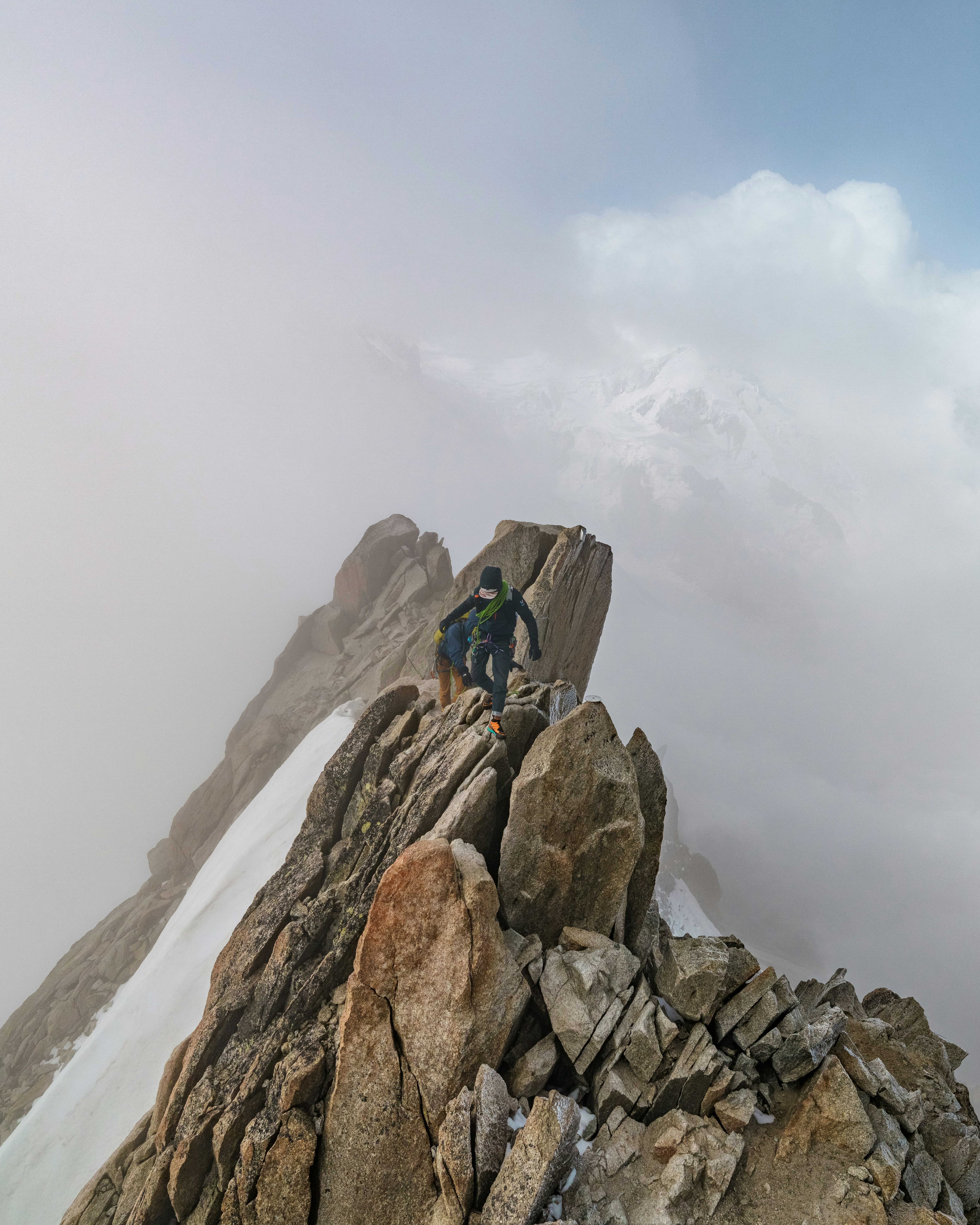Summit Stance: A Climber Carving Through a Jagged Crest
