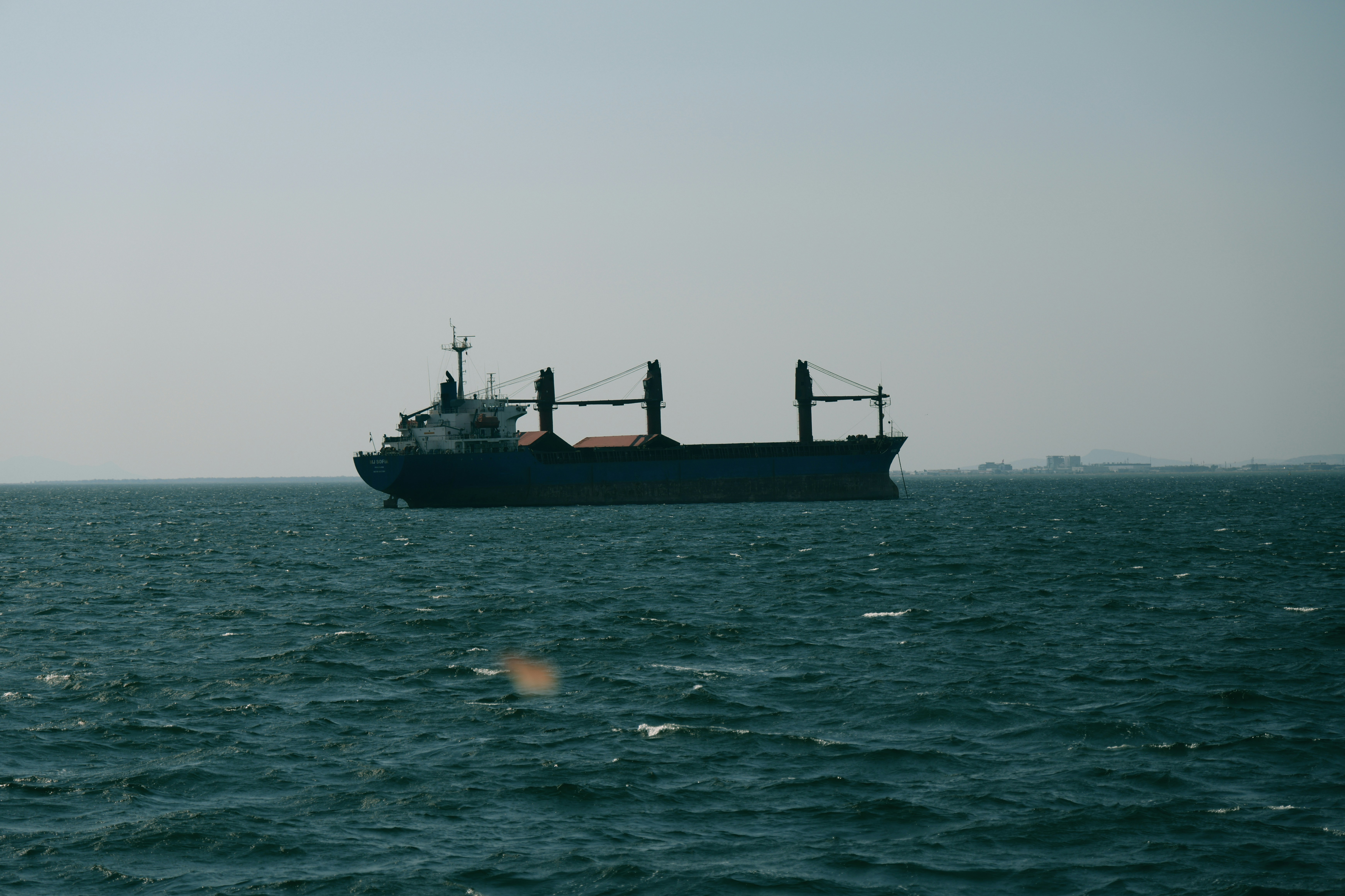 Horizon Vessel: A Lone Freighter Traversing a Quiet Sea