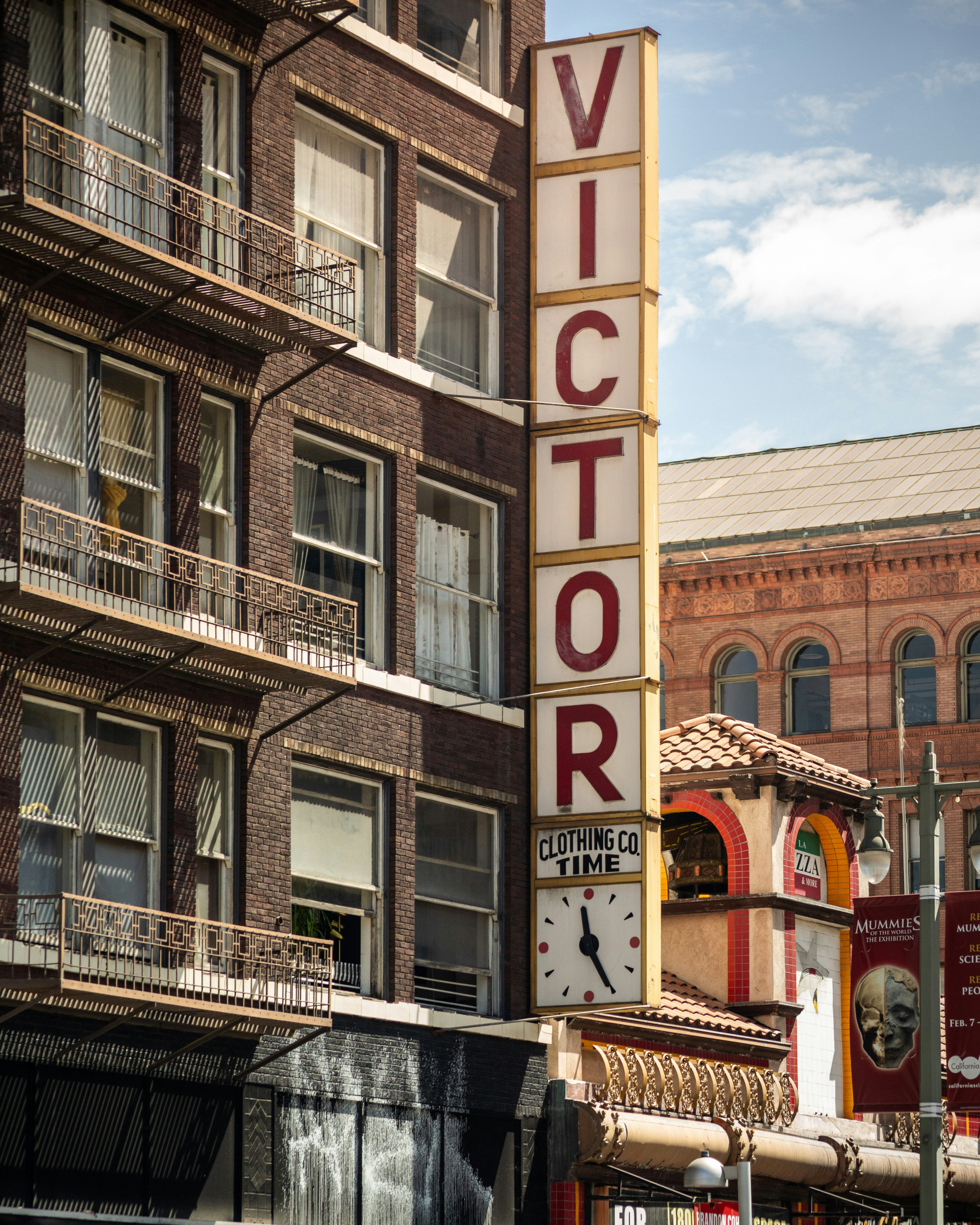 Vintage 'victor' sign on a brick building with a clock.