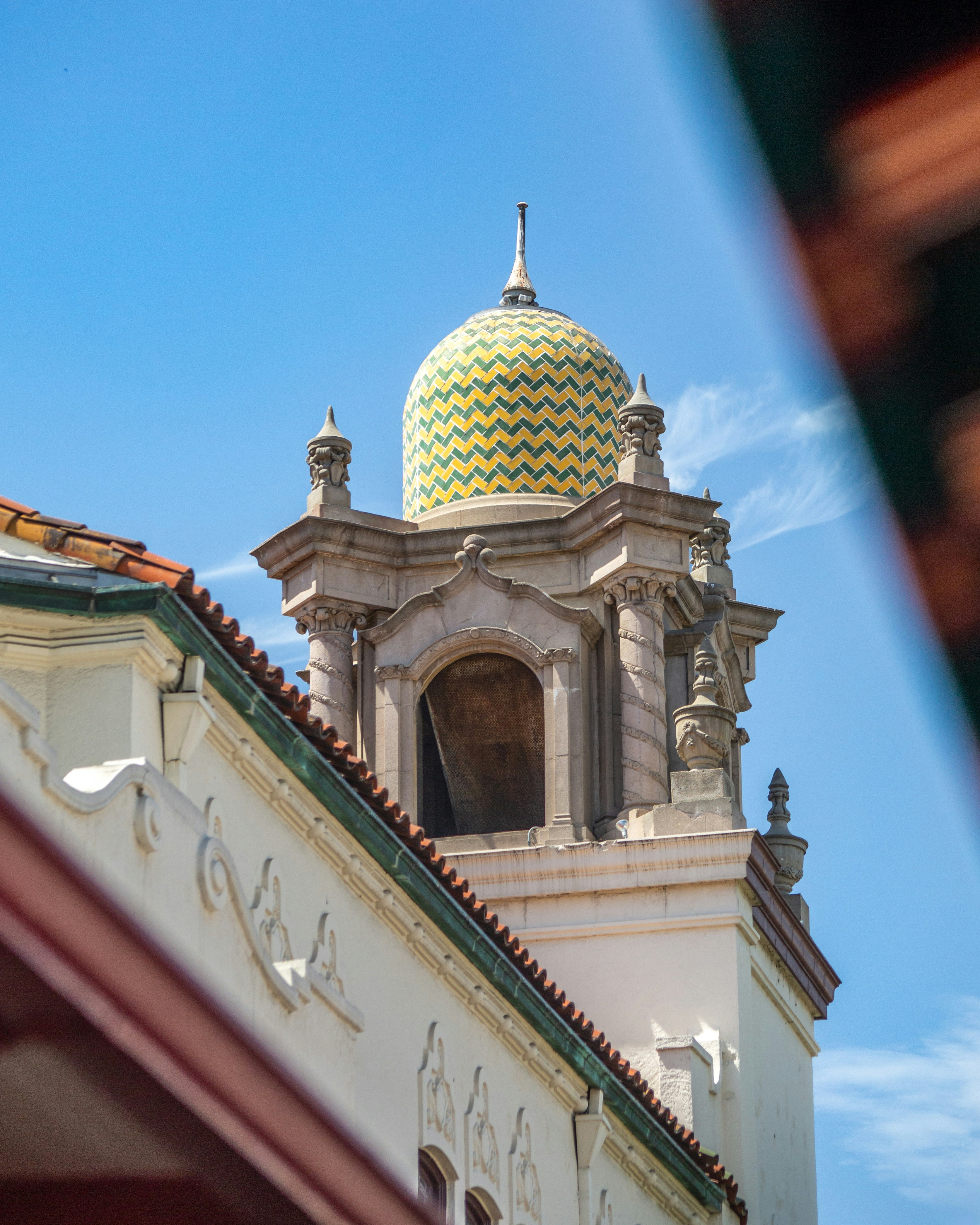 Turkish-style tiled dome rising above ornate church tower