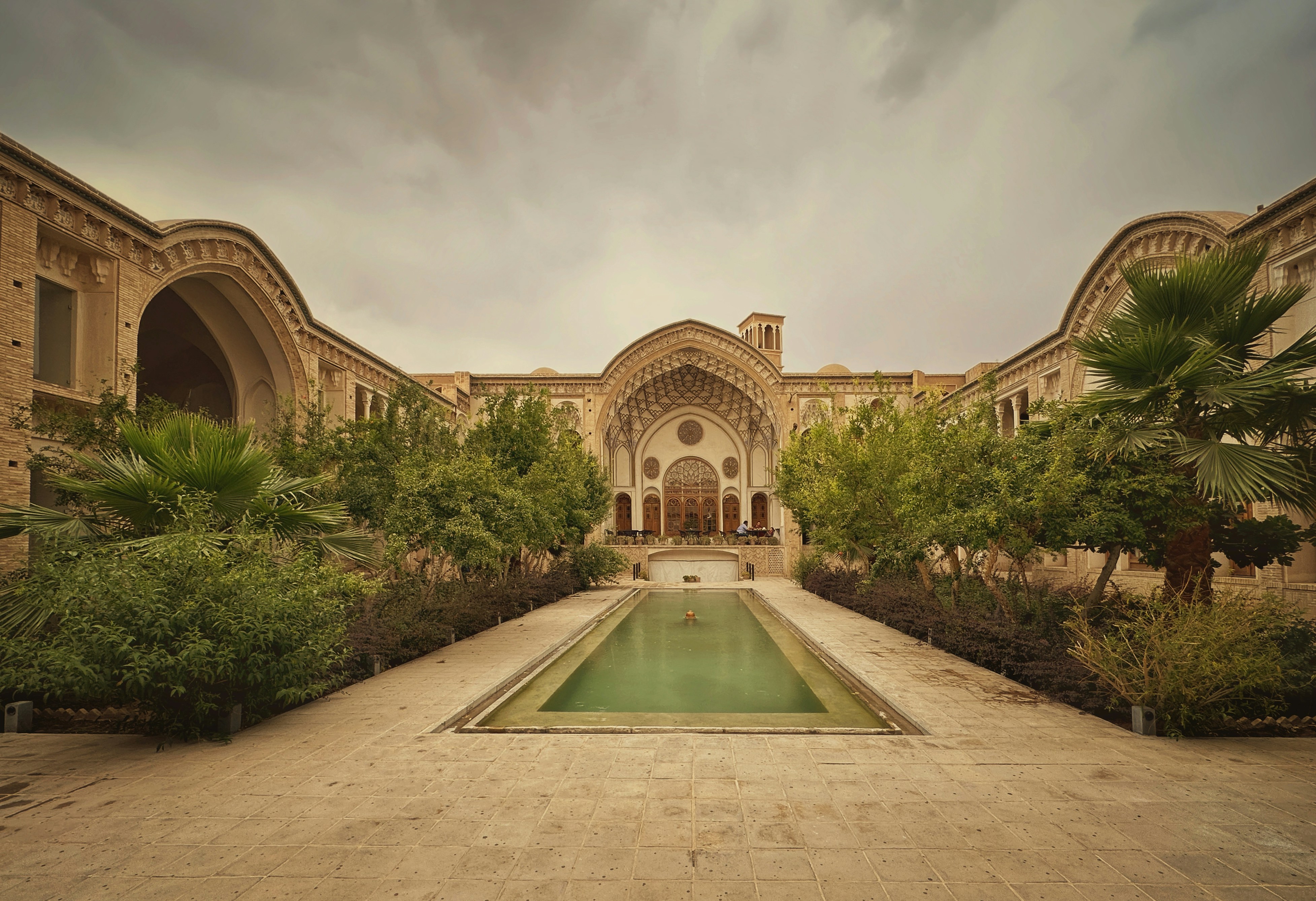Symmetrical Oasis: The Central Fountainway Surrounded by Historic Arches
