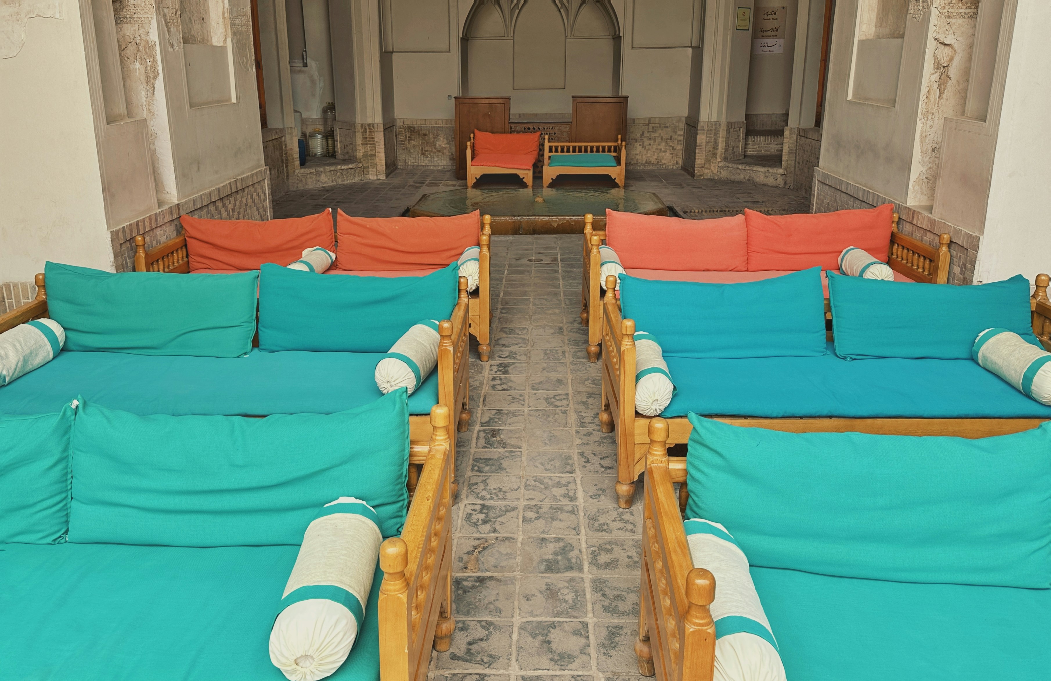 Teal Cushions, Orange Backrests: An Array of Daybed Comfort in a Courtyard Setting