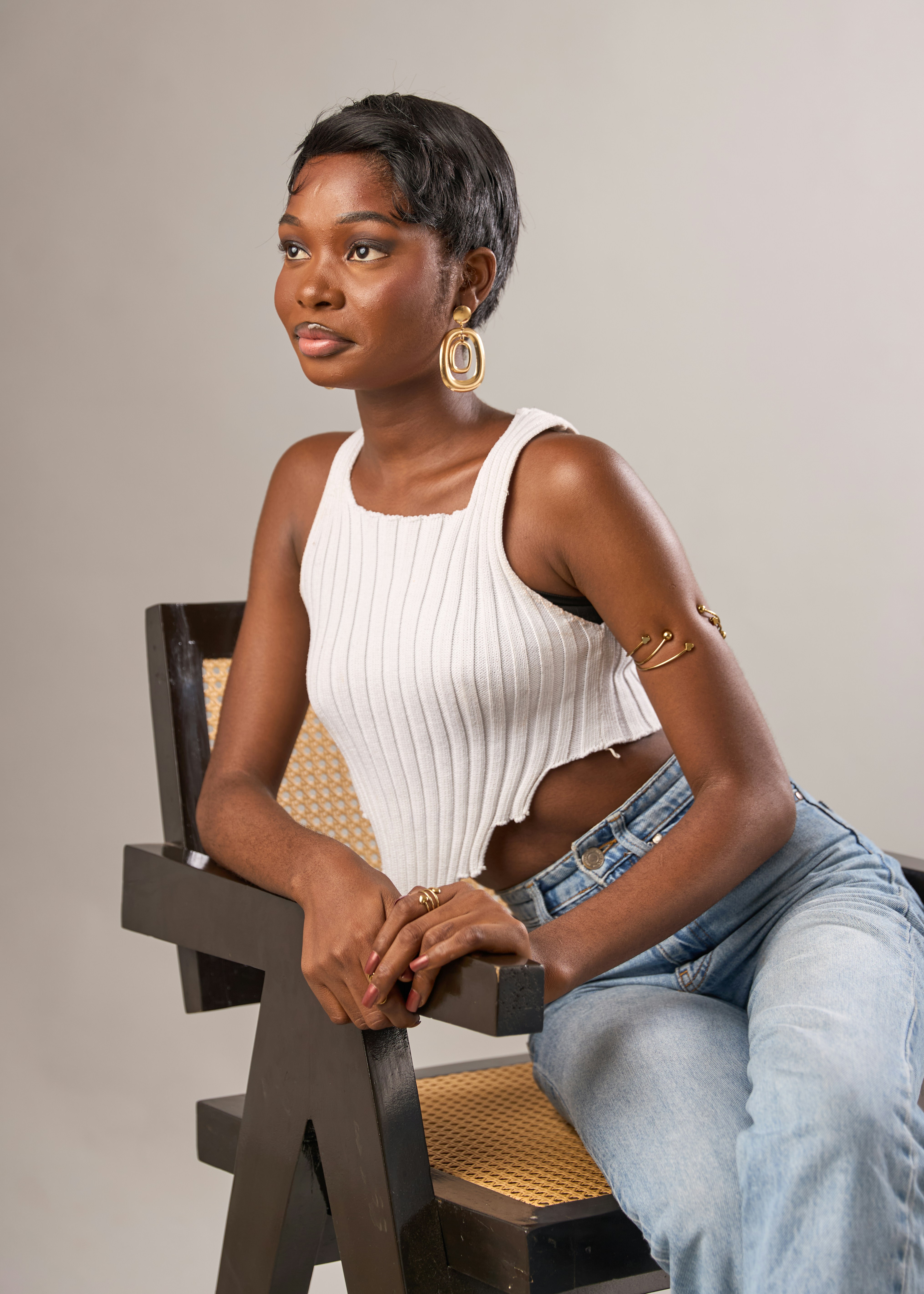 Portrait in White Knit: Quiet Confidence on a Studio Chair