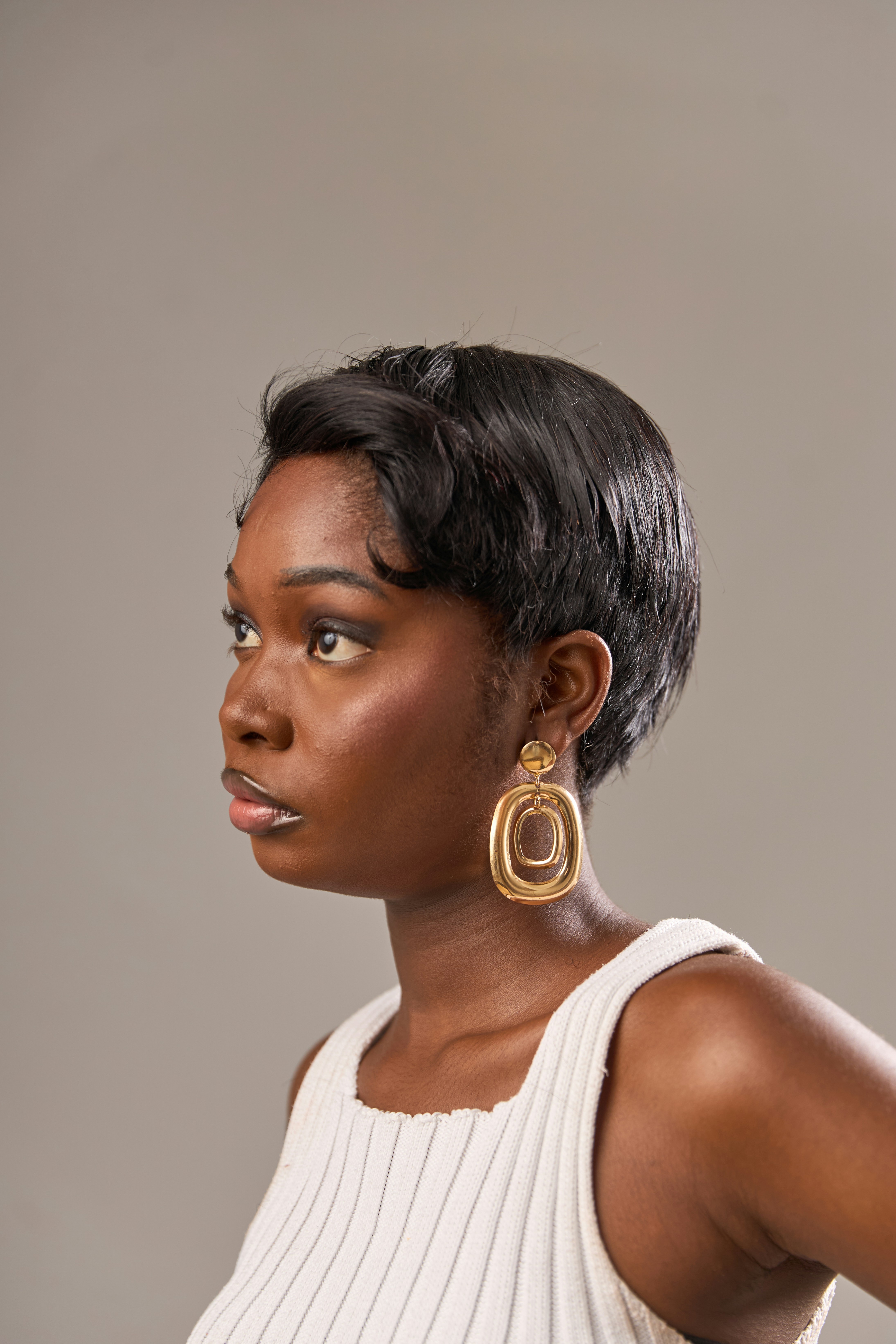 Graceful portrait: a poised gaze with bold golden earrings