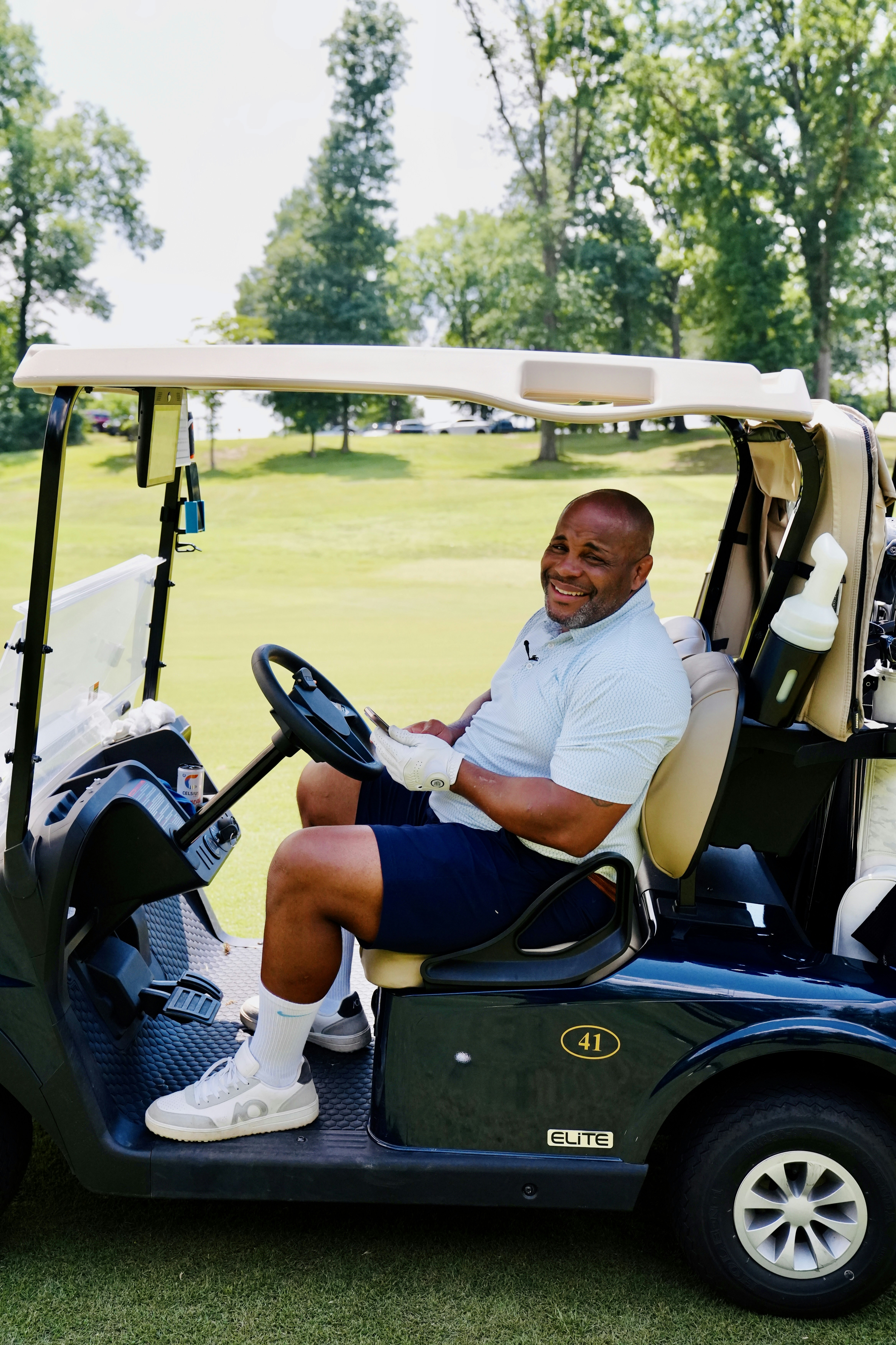 Smiling golfer in a golf cart ready for the next hole