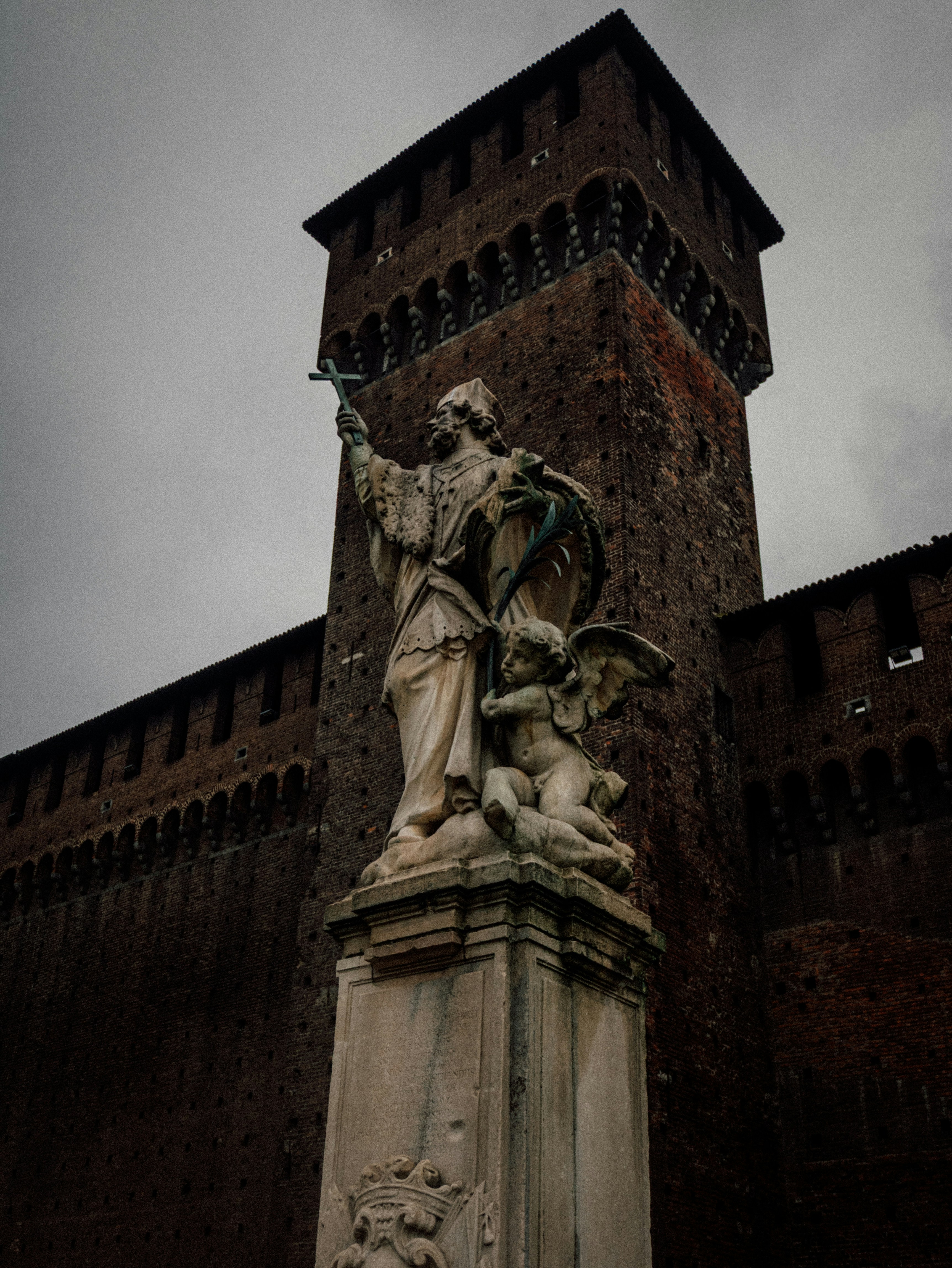 Stone Sentinel: statue foreground with towering medieval fortress
