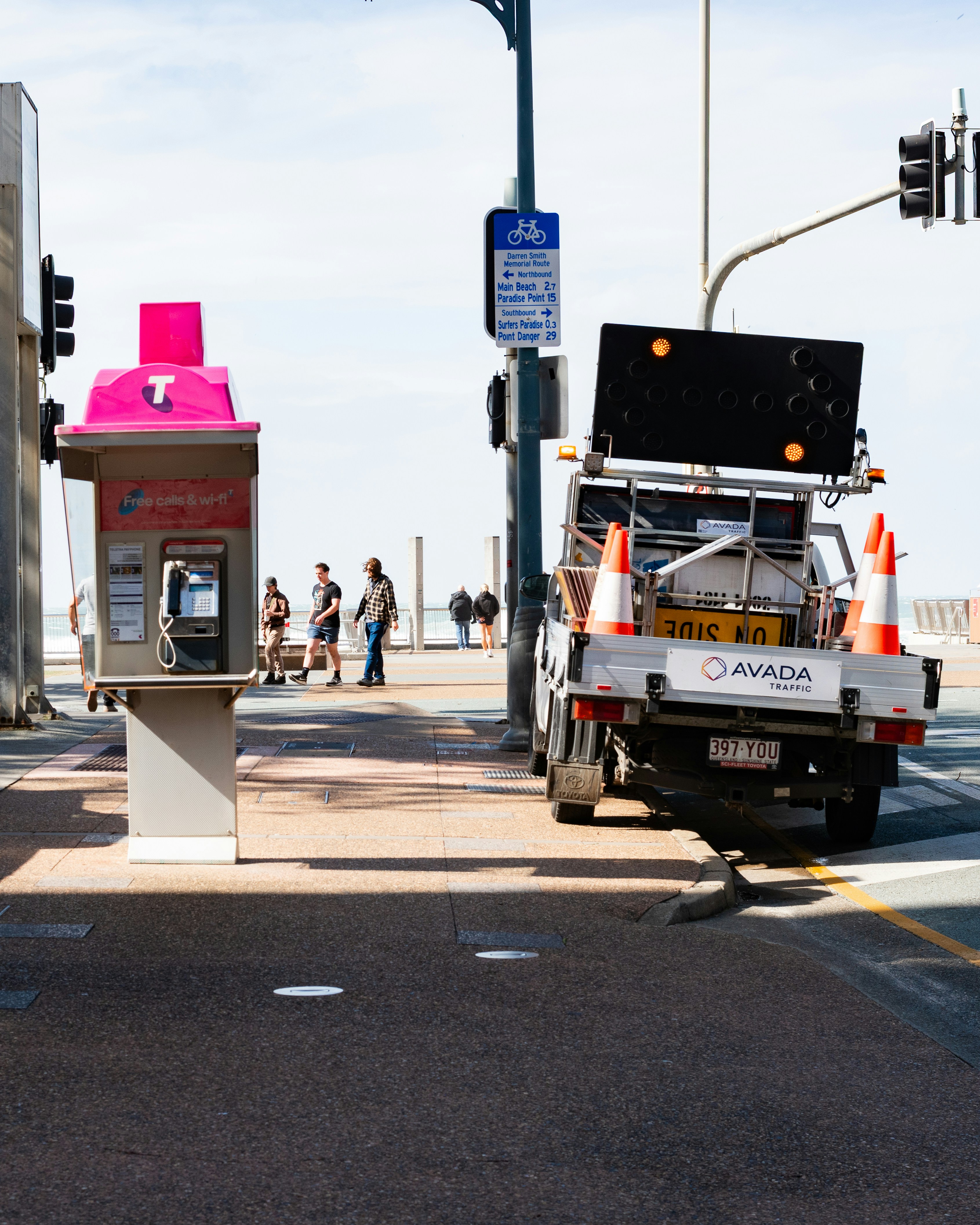 Boardwalk Corridor: A Service Truck and a Pink Kiosk Beside the Waterfront