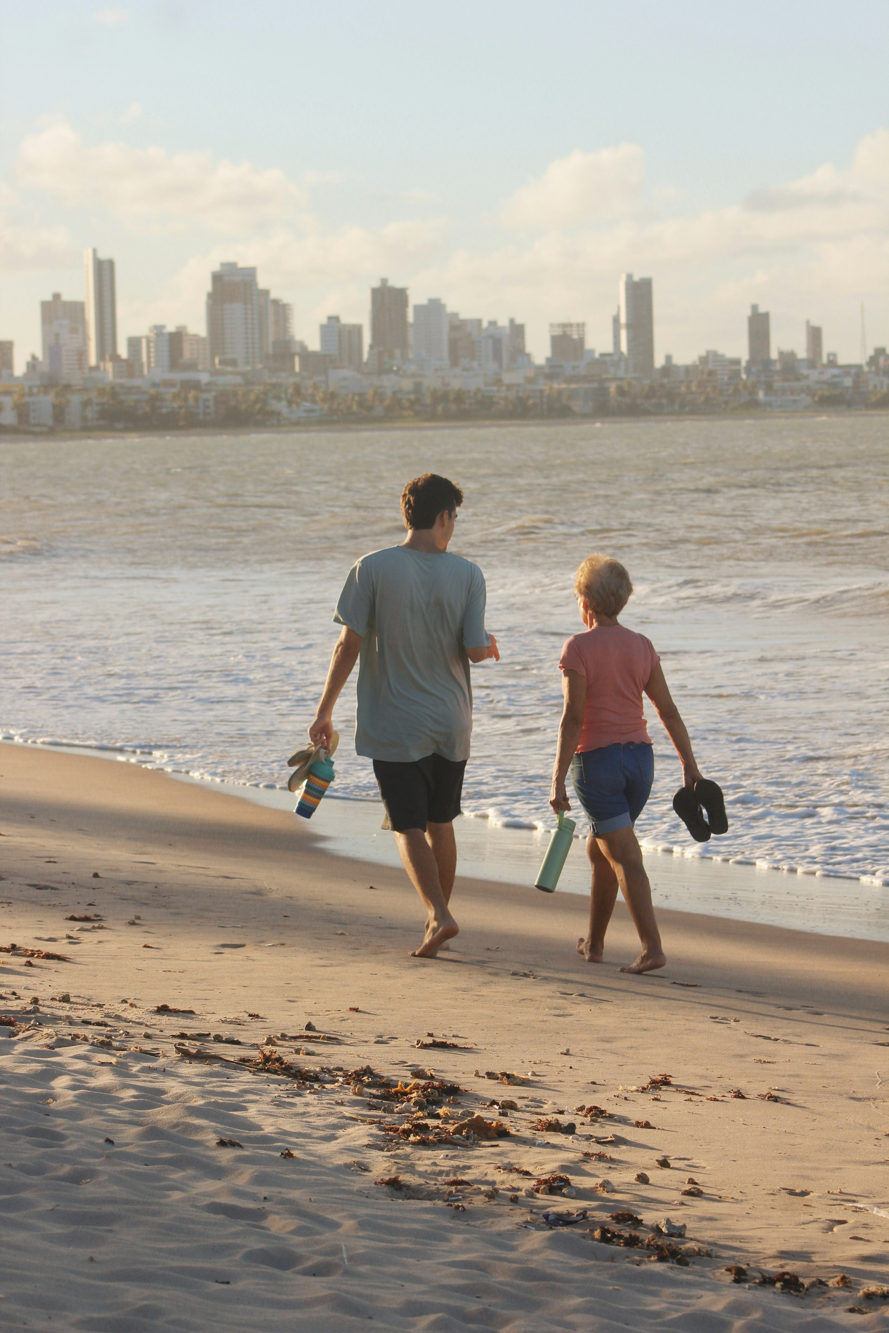 Footprints and Cityscape: A Beach Walk with Shared Purpose