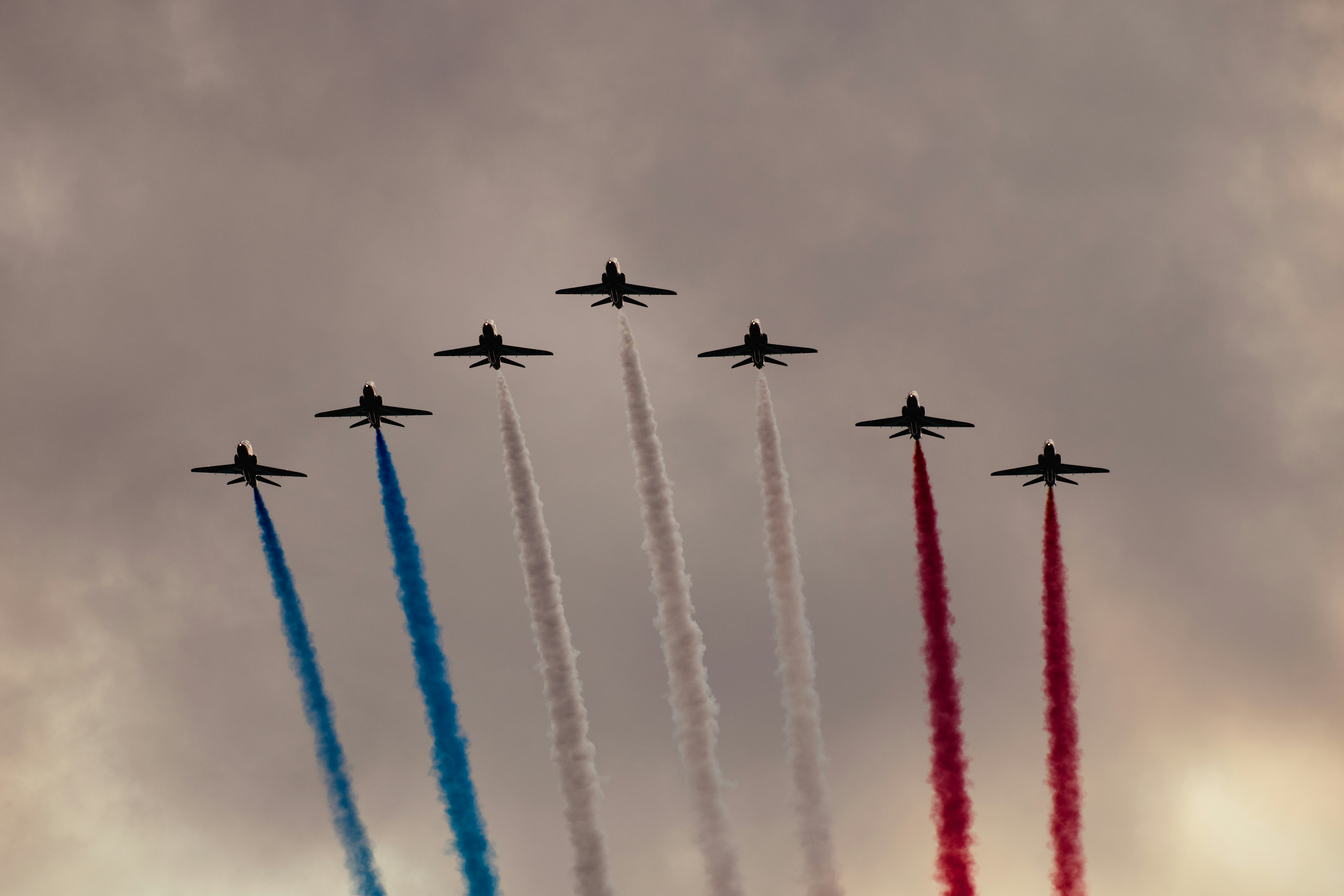 Triumphant Formation: Color Trails Across a Clouded Sky