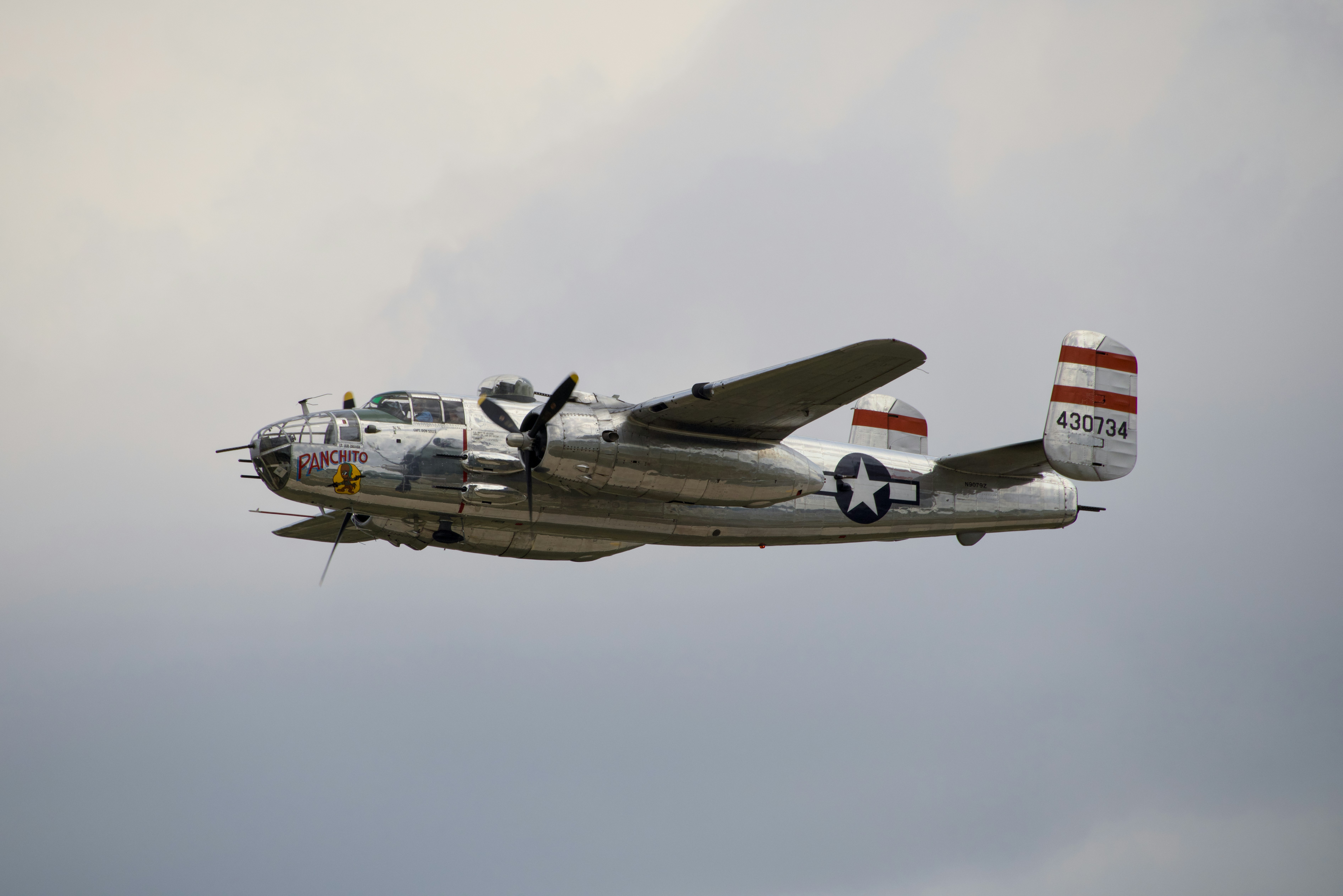 Silver Ghost in the Skies: WWII-era Liberator glides through muted clouds