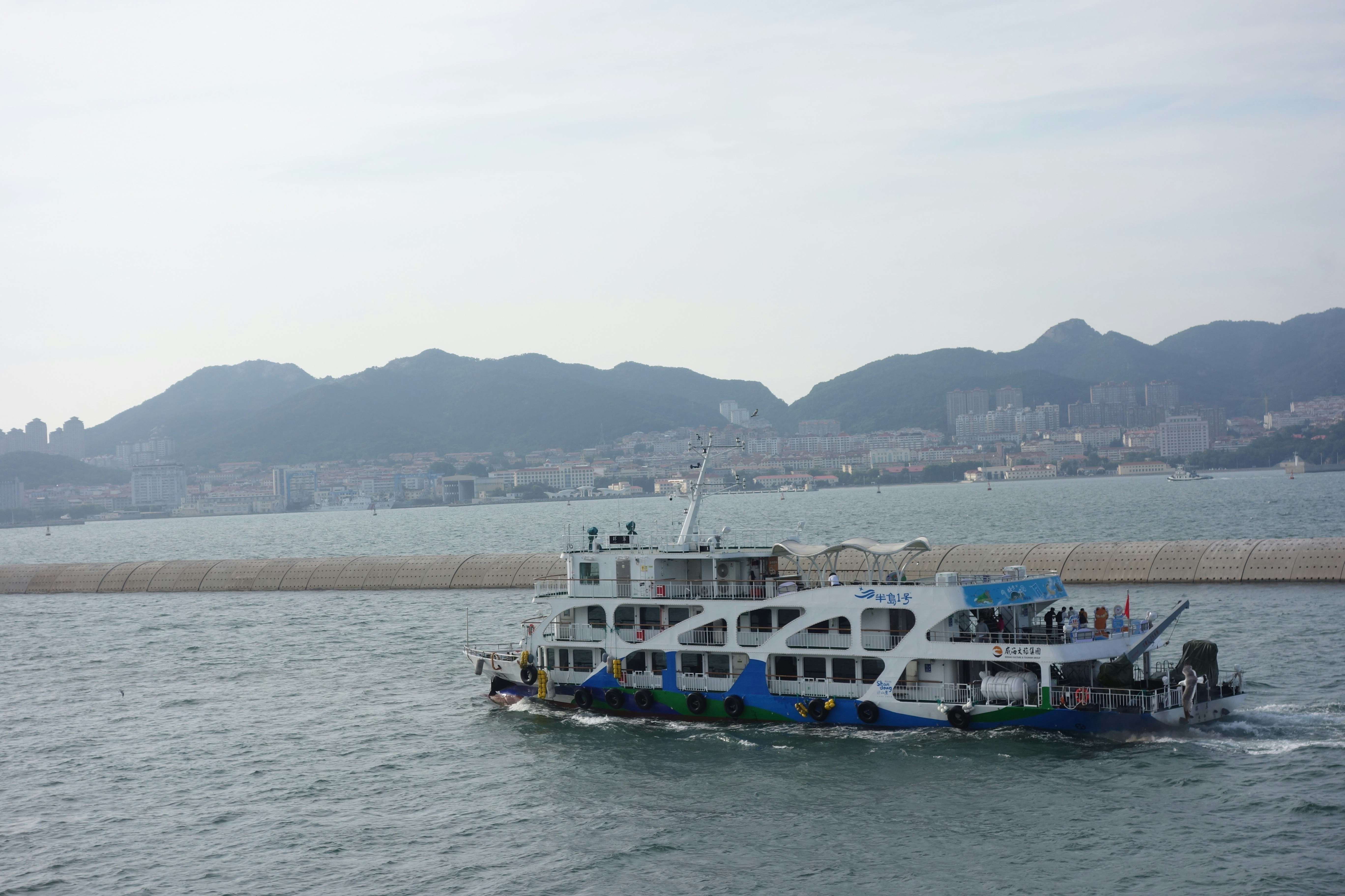 Blue-and-White Ferry Cutting Across Calm Bay