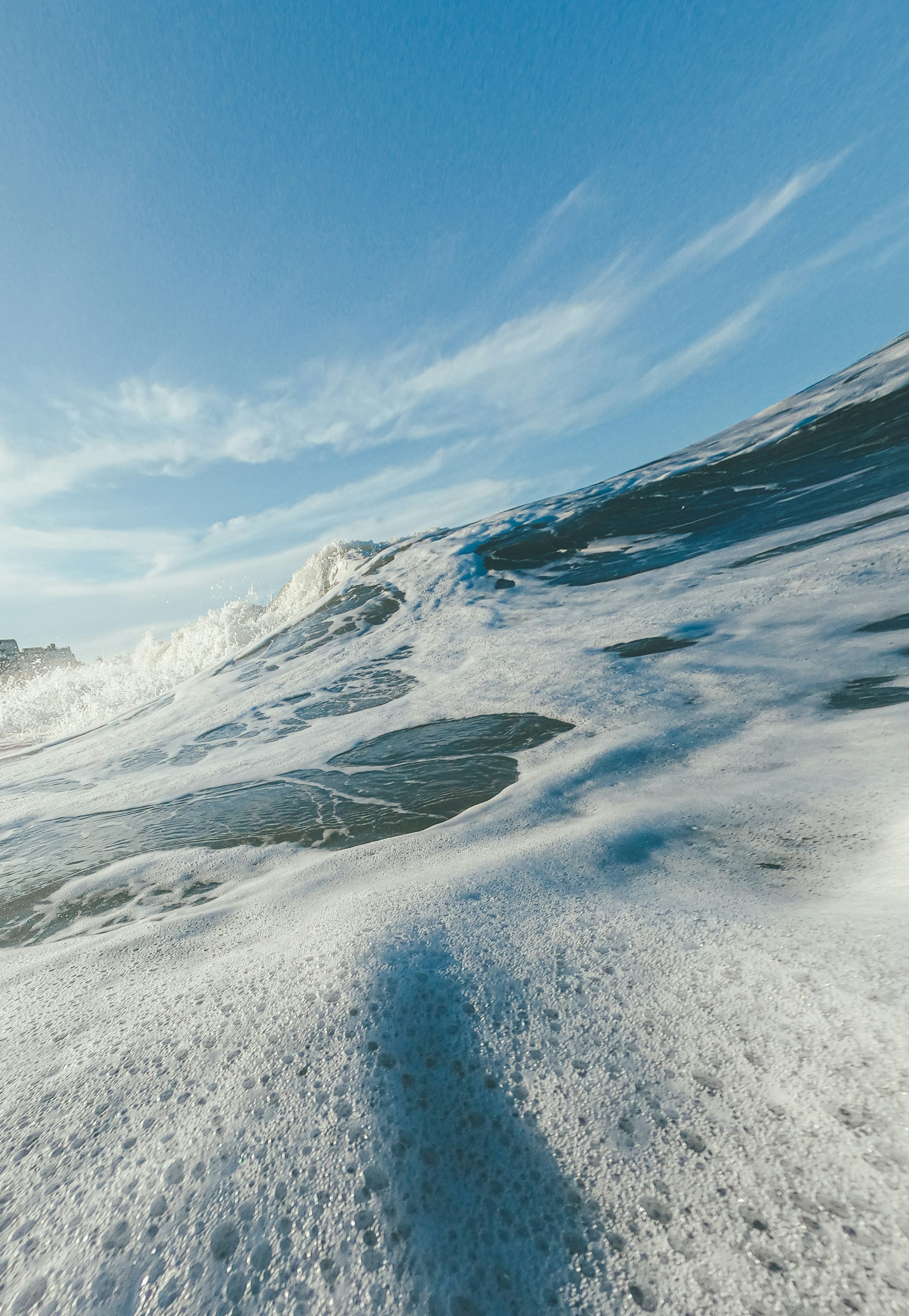 Surfacing through frozen white: a cresting wave from the camera’s low vantage