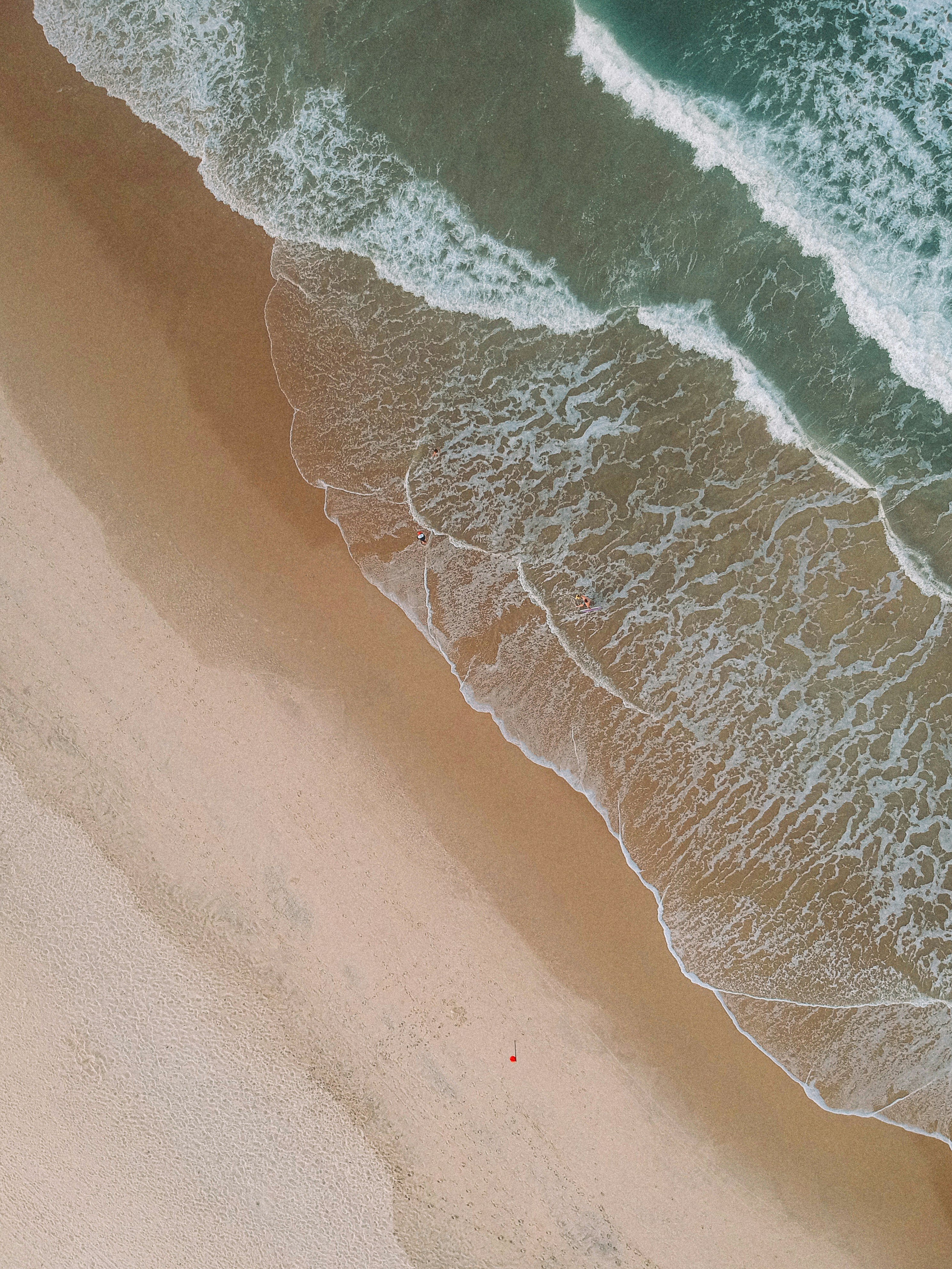 Gentle Coastal Boundary: Aerial View of Tide Wash on Empty Shore