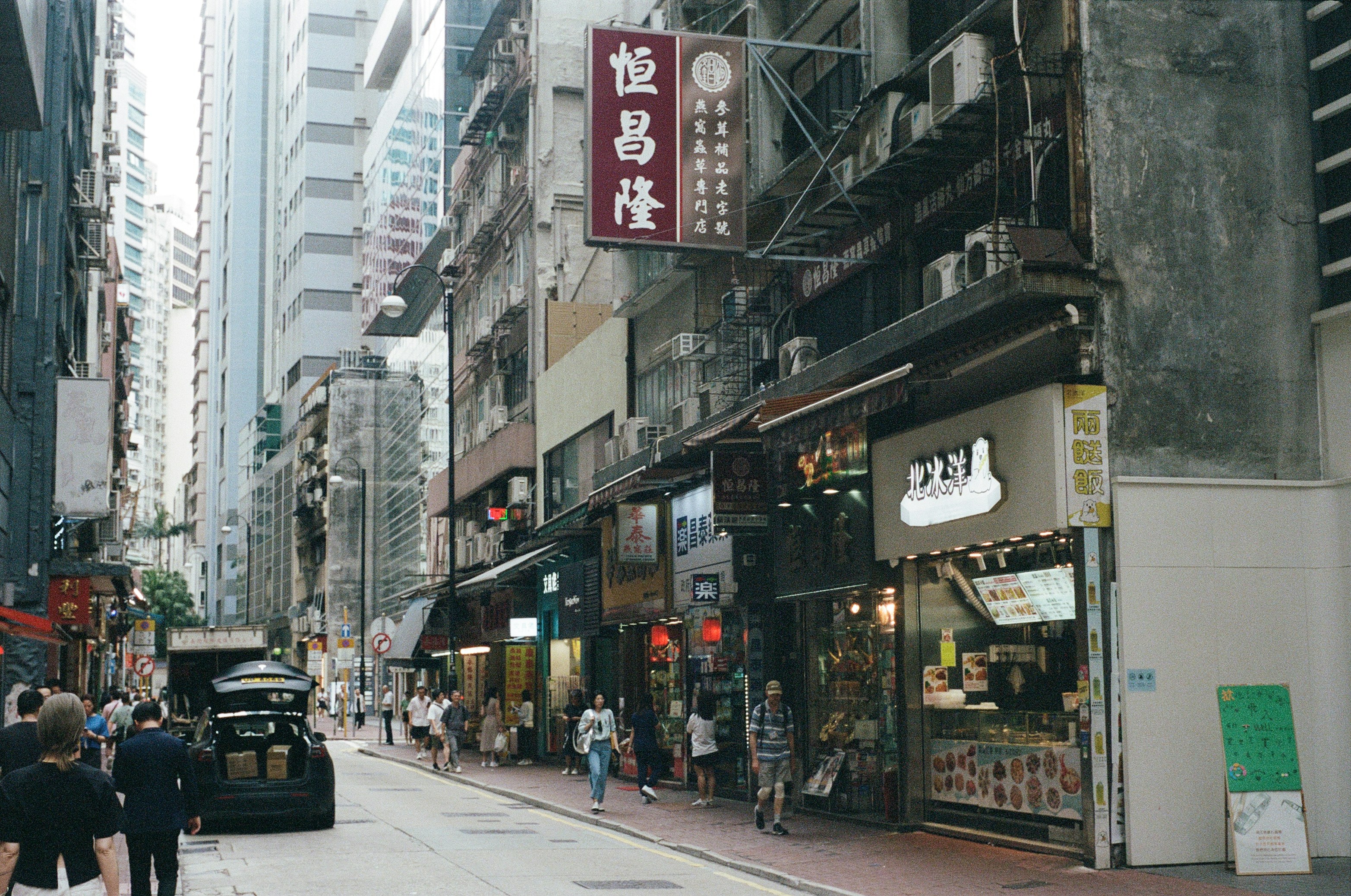 Street Life Under Neon Signs: A Moment in a Busy Asian Thoroughfare