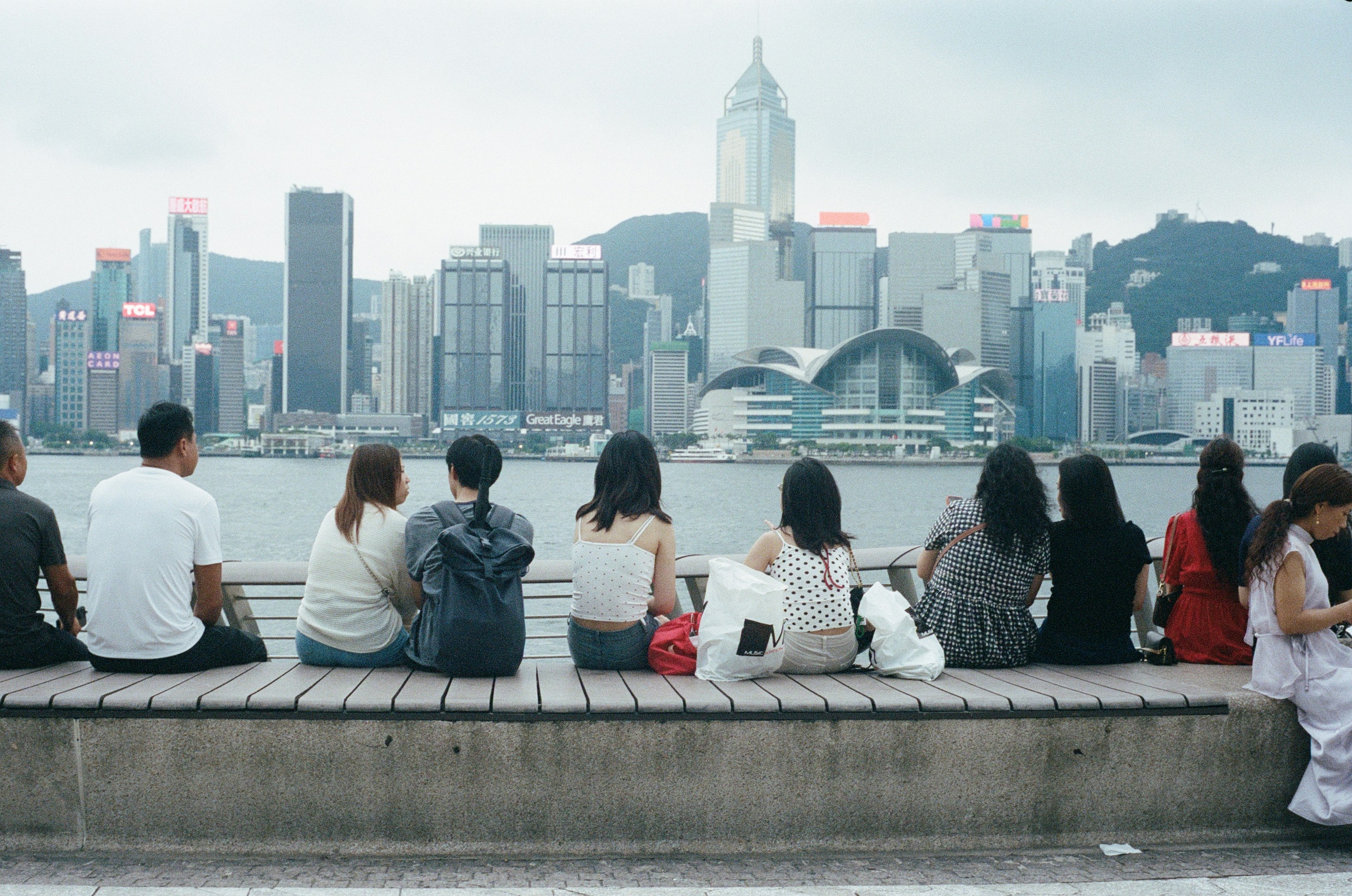 Seated silhouettes with a skyline horizon across the water