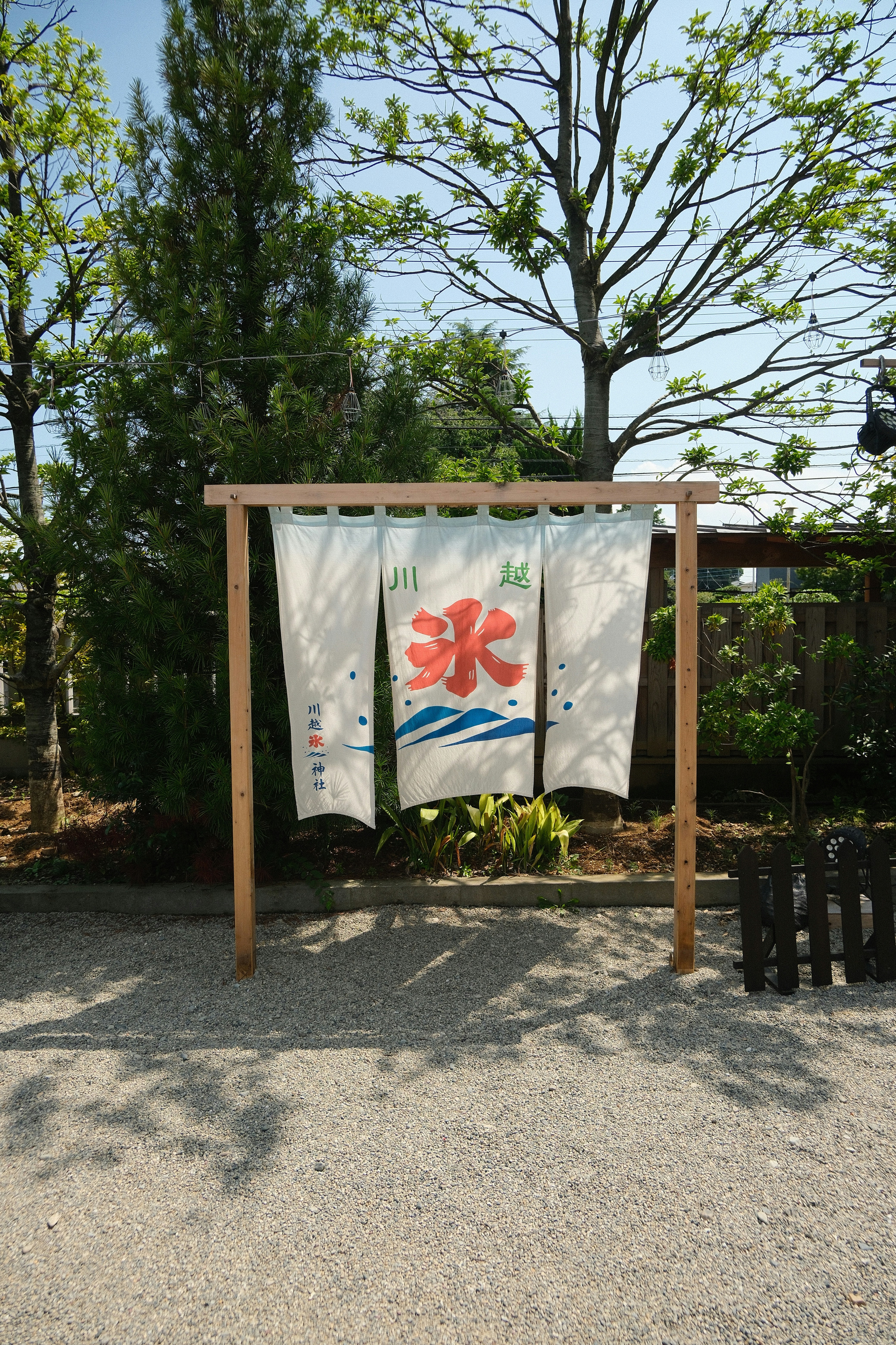 Sacred Curtain: A Quiet Shrine Banner Framed by Spring Green