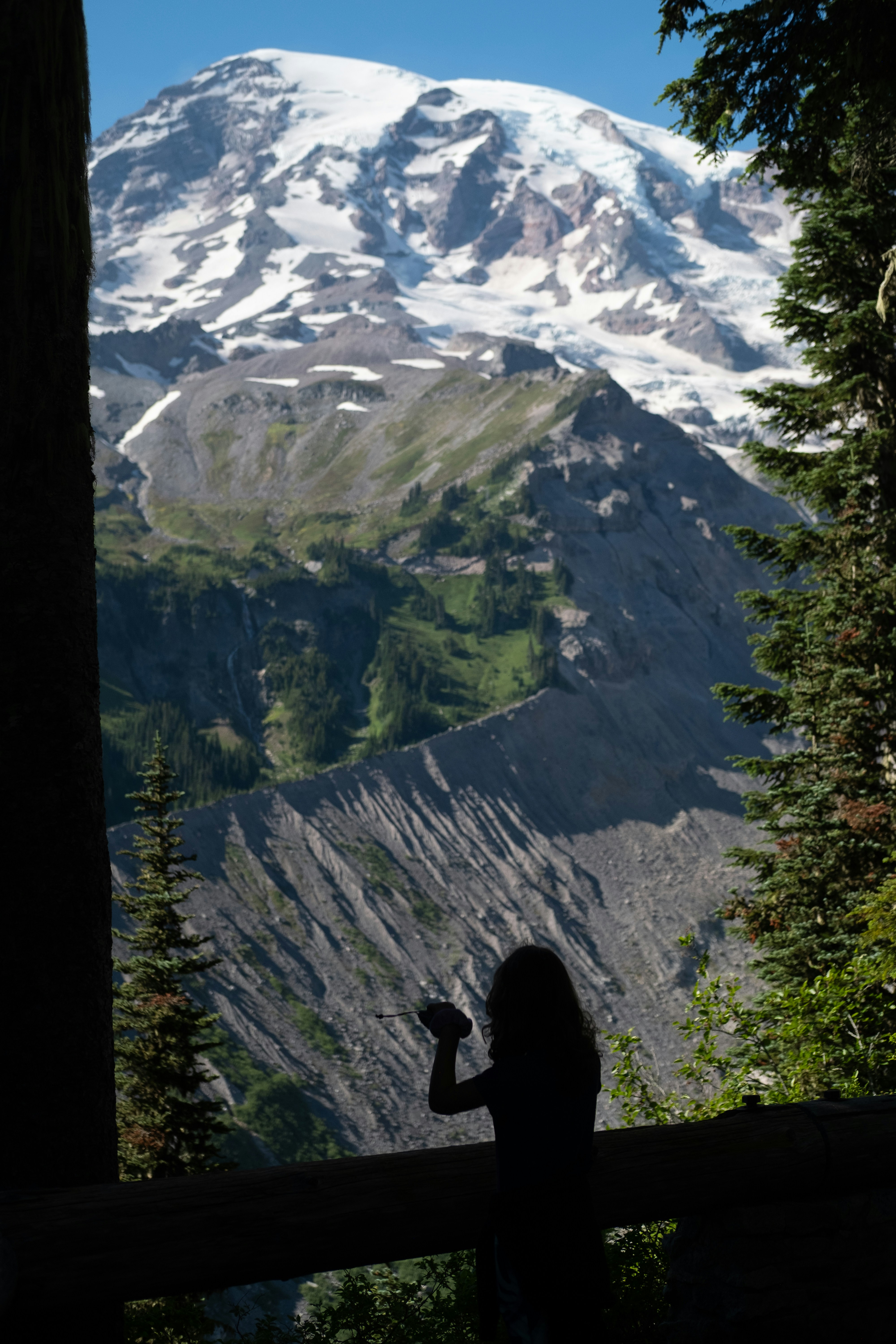 Silhouette at the Gate: A Mountain Vista Framed by Shadows
