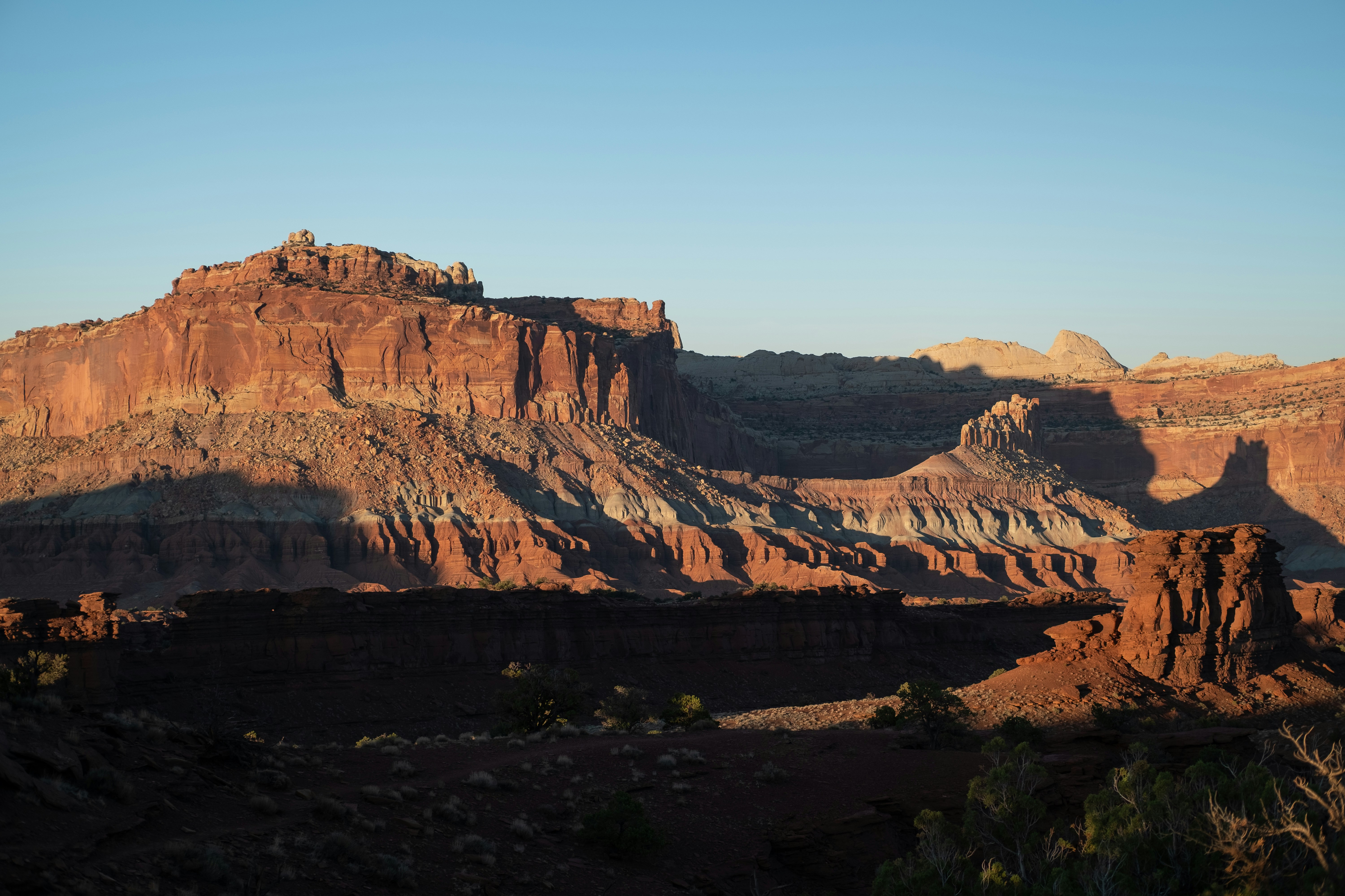 Desert Sentinel: Sunlit Cliffs Over a Quiet Basin