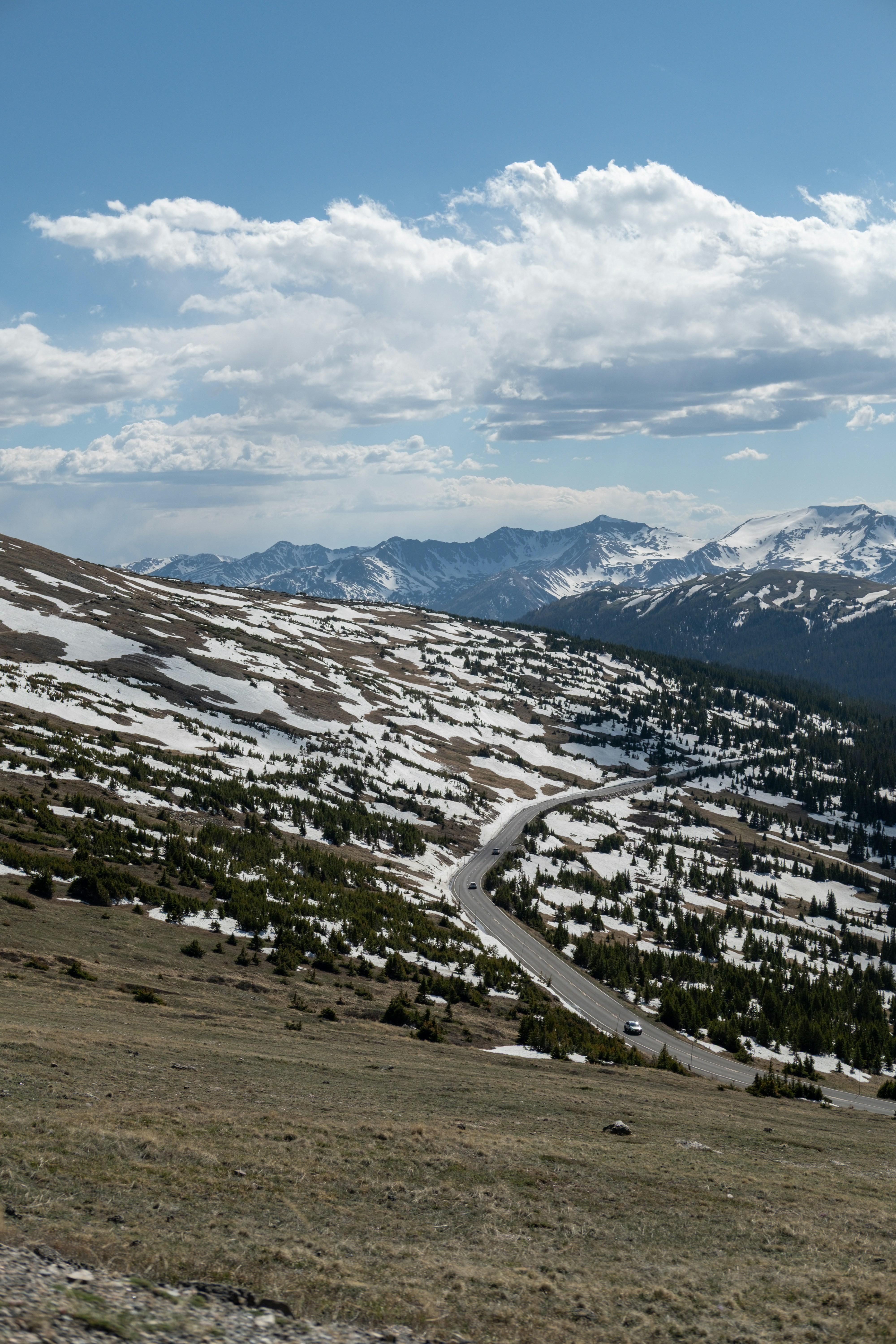 Curved Mountain Pass Beneath a Sky of Looming Clouds