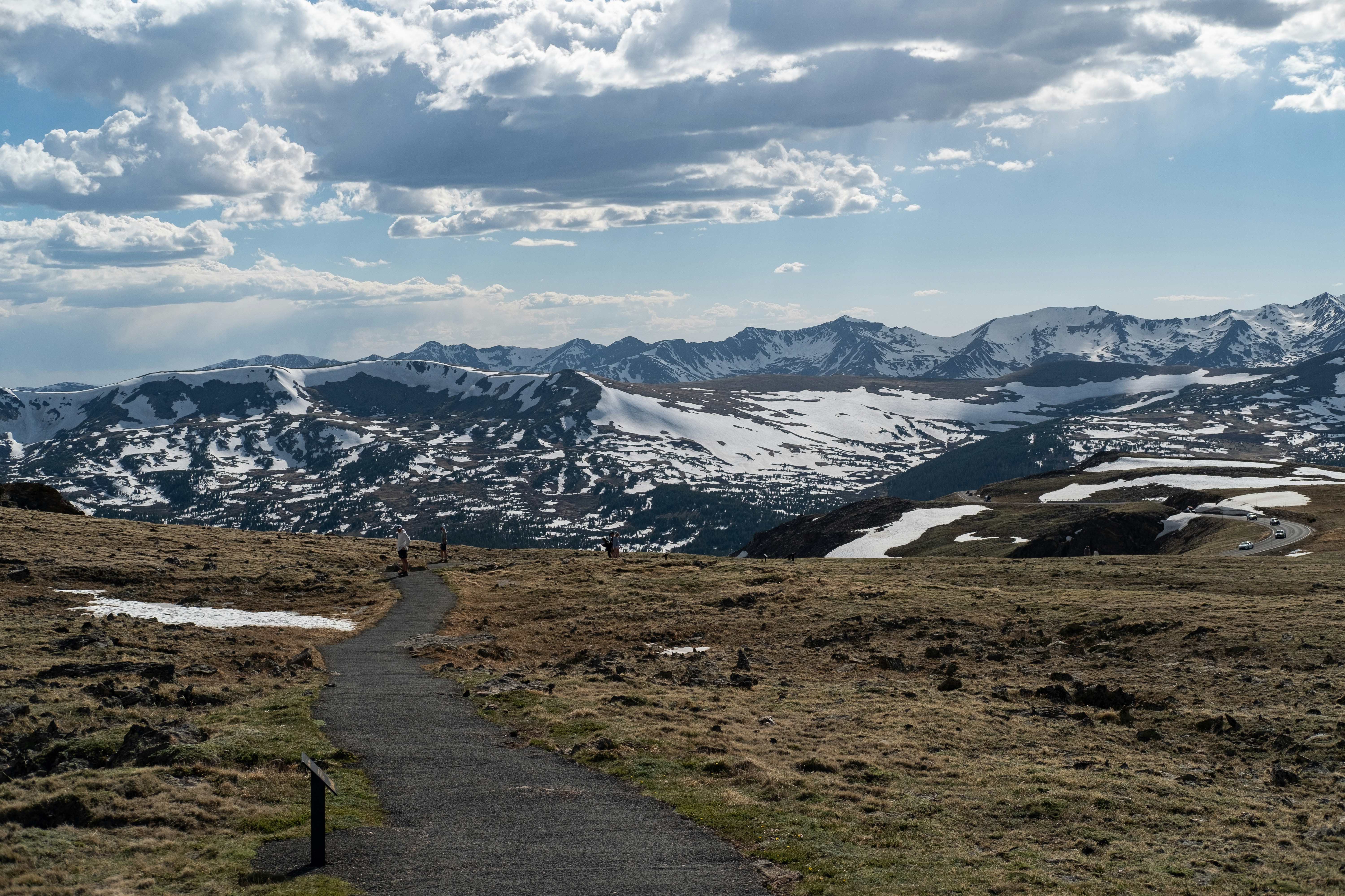 Trail to Snow-Washed Peaks under a Patchwork Sky