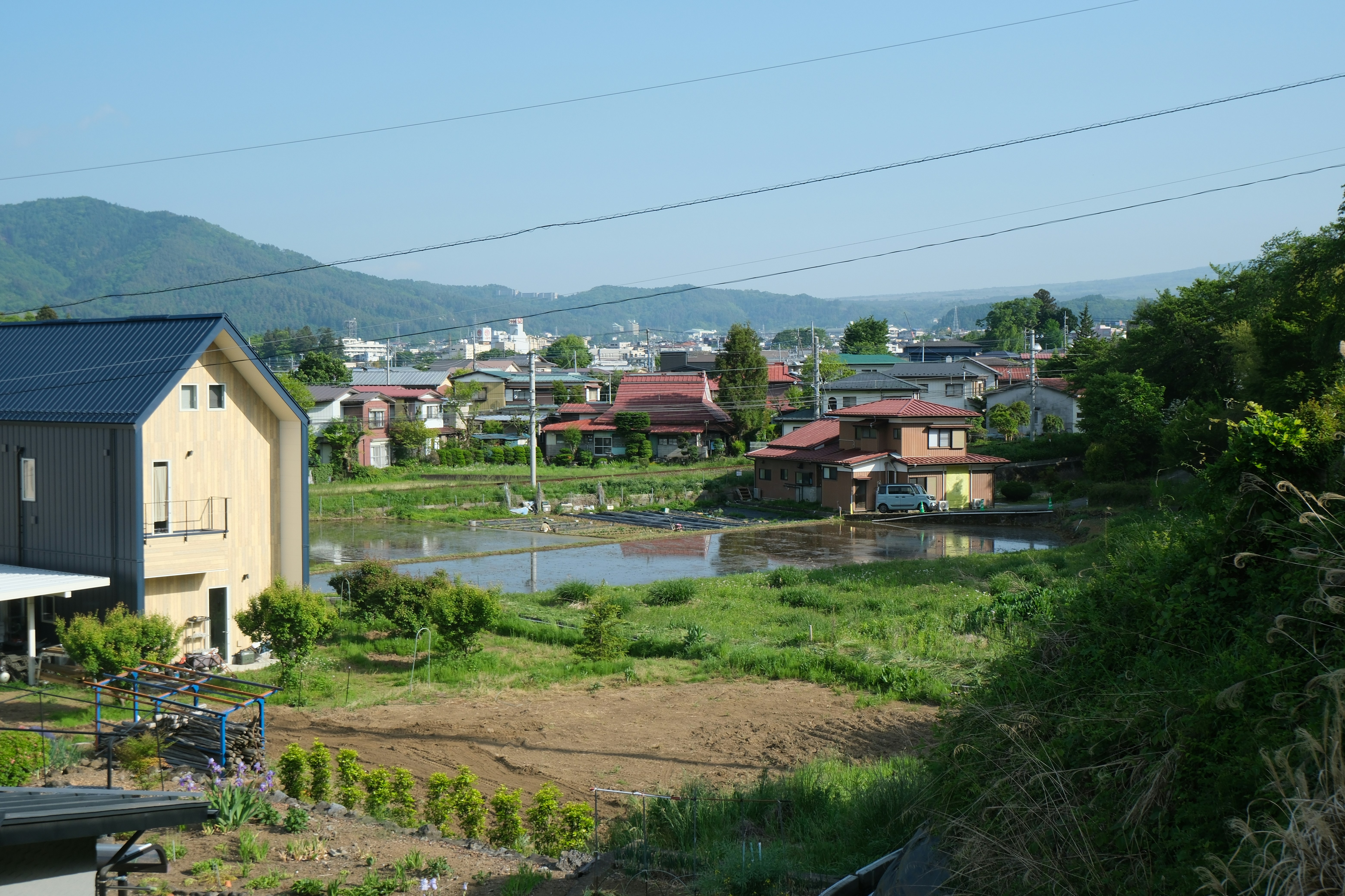 Sunny village by the river with clustered homes and distant hills