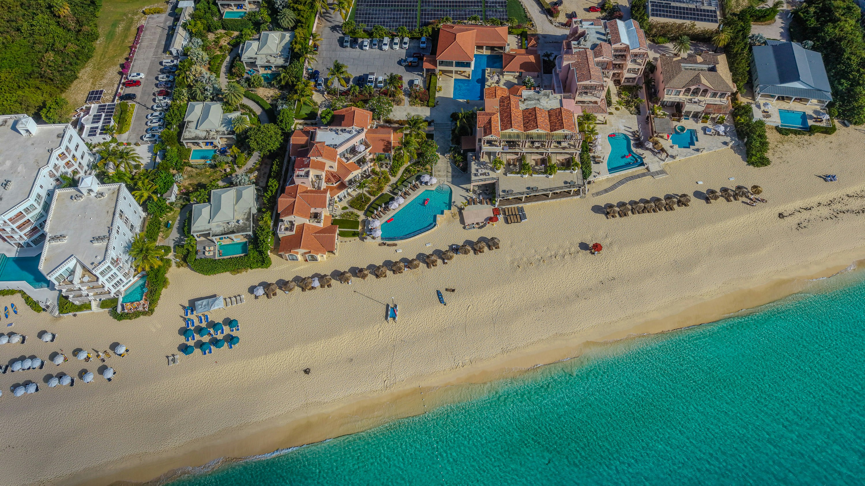 Aerial Retreat: Beachfront Dunes, Villas, and Turquoise Reef