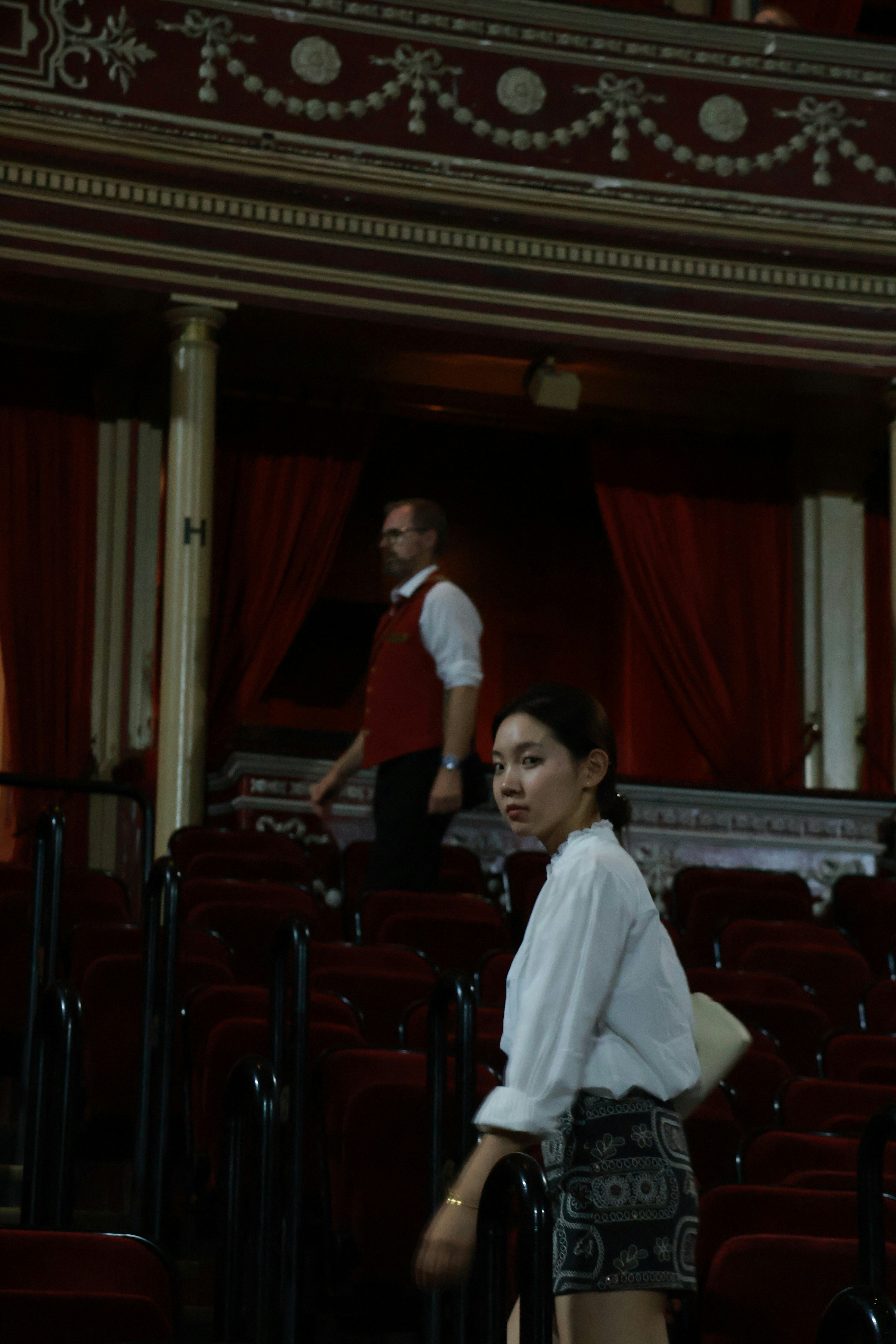 Quiet Spotlight: A Distracted Dancer in Red Velvet and White Blouse
