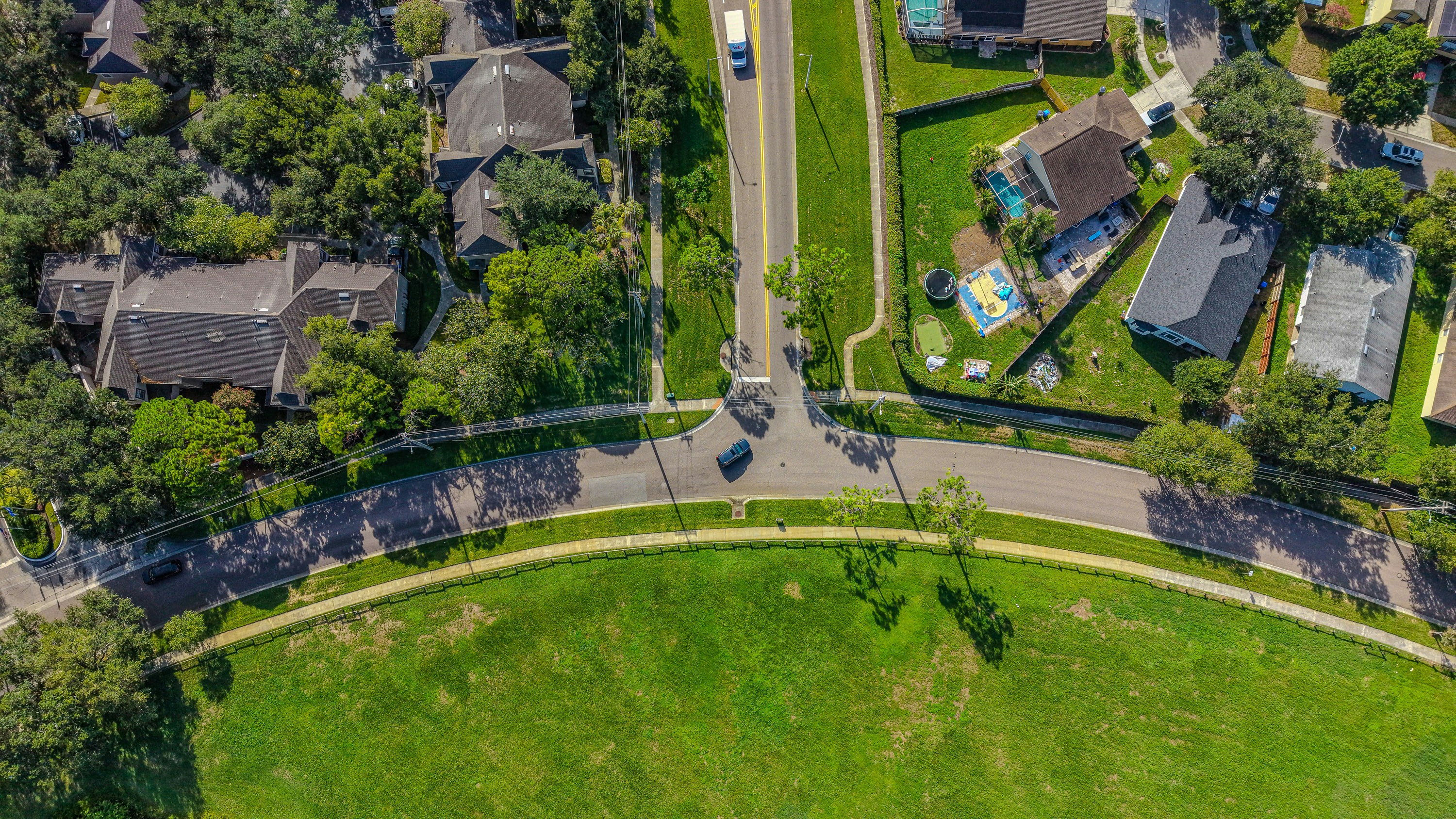 Curved street intersecting a quiet suburban park as seen from above