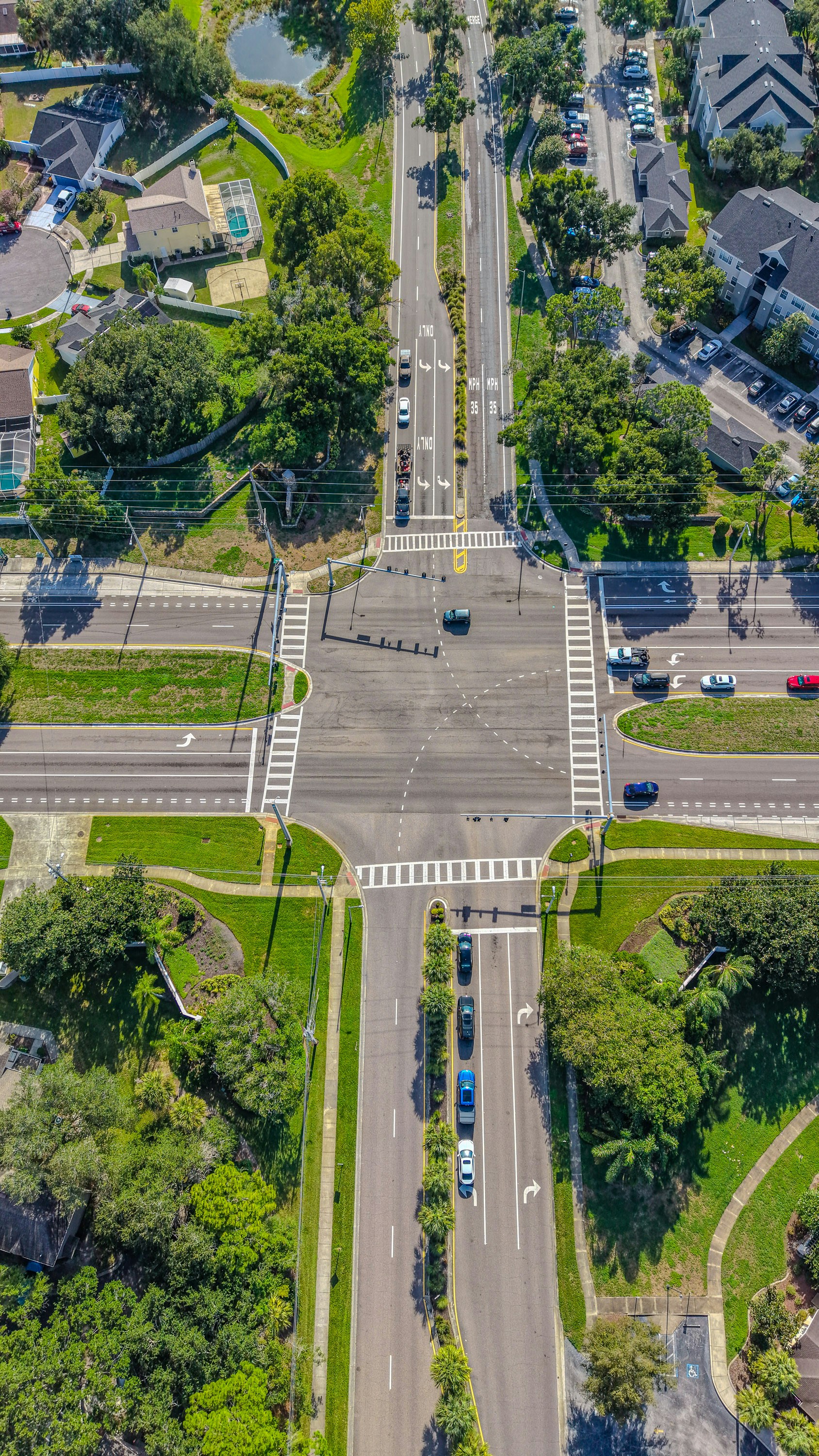 Crossroads Horizon: Aerial View of a Suburban Intersection Aligned with Tree Lined Avenues