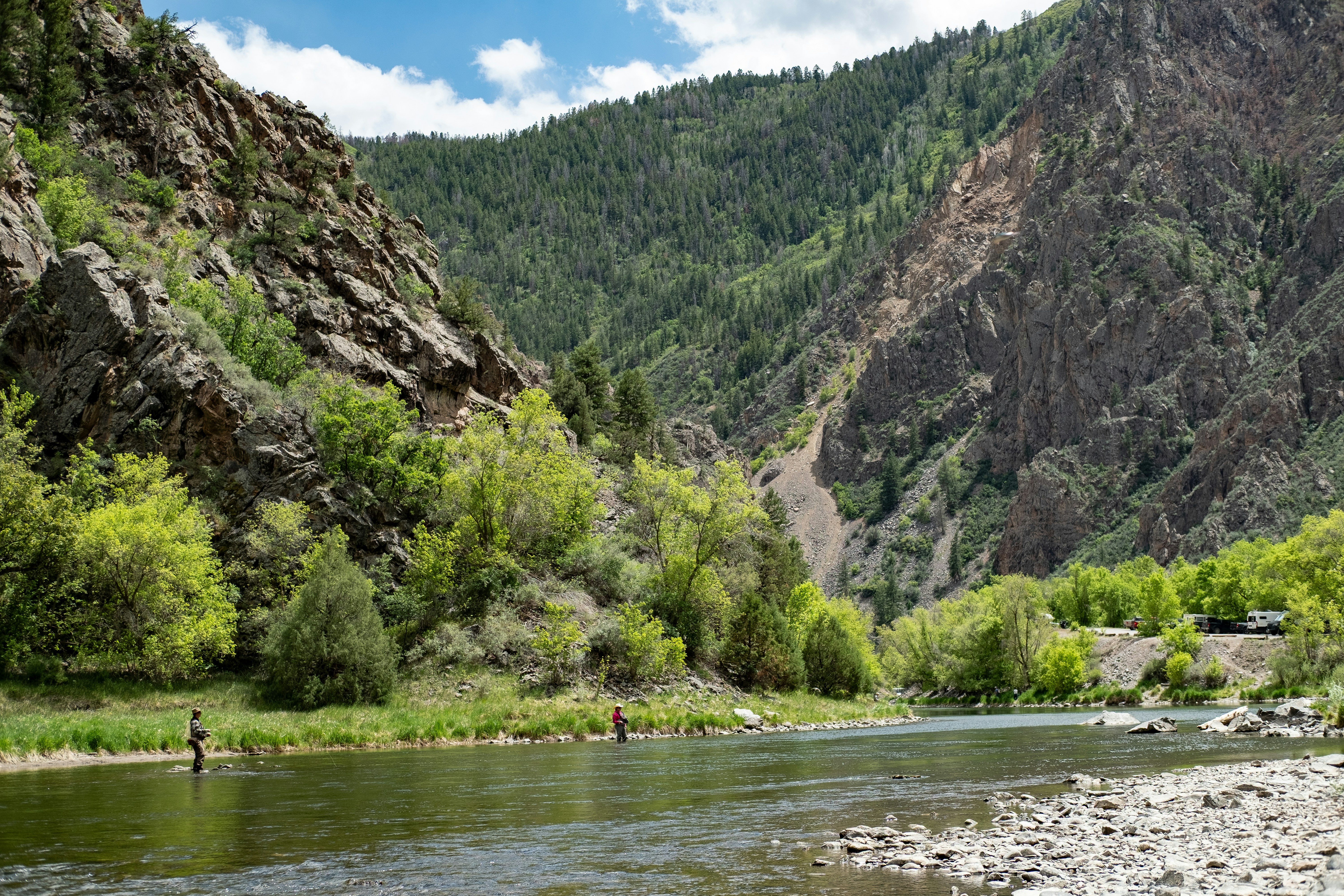 River runners beneath towering canyon walls