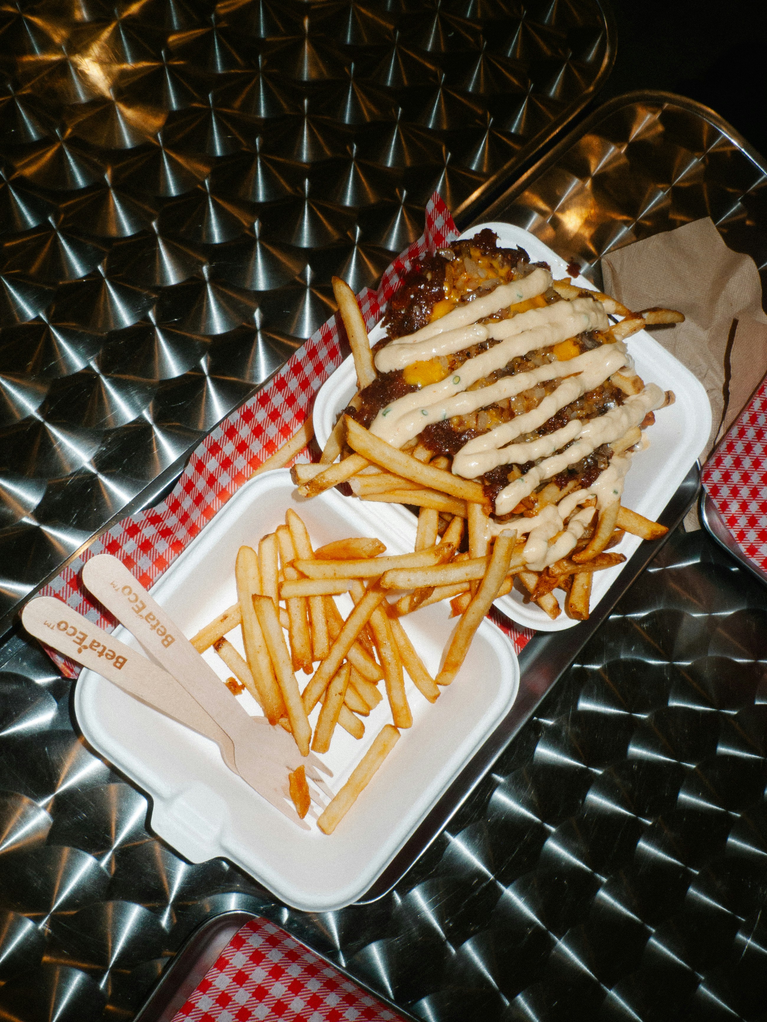 Loaded Smash Burger with Drizzled Sauce and Side Fries on a Checkered Tray